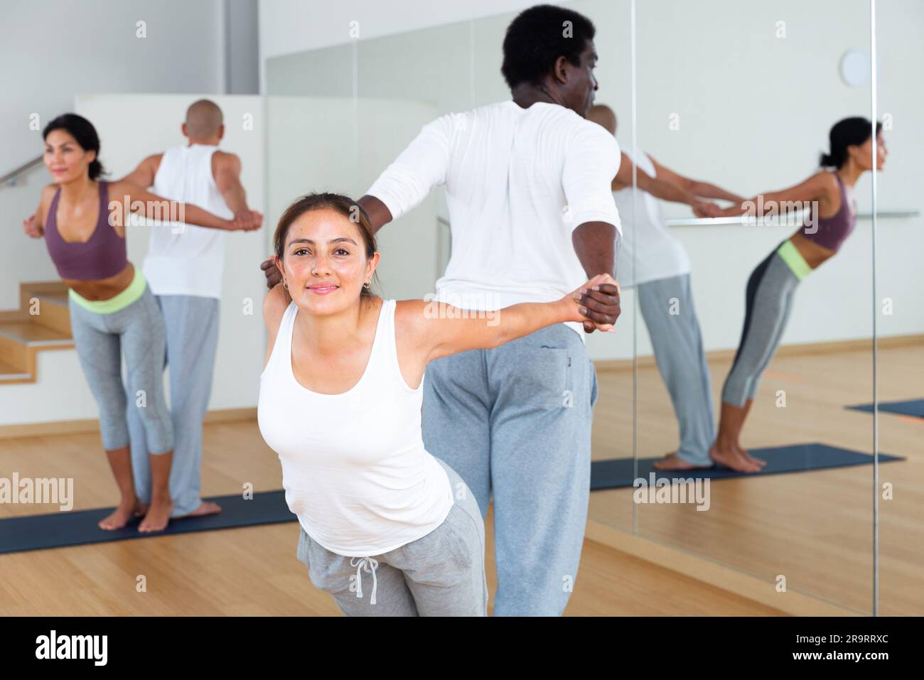Couples practicing yoga with partner at studio Stock Photo - Alamy