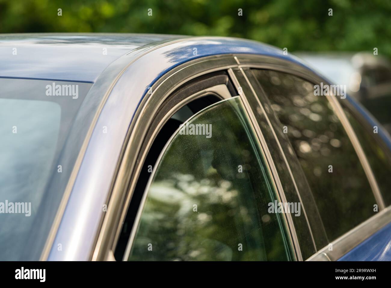 Closeup of slightly ajar car window for better cooling on hot summer ...
