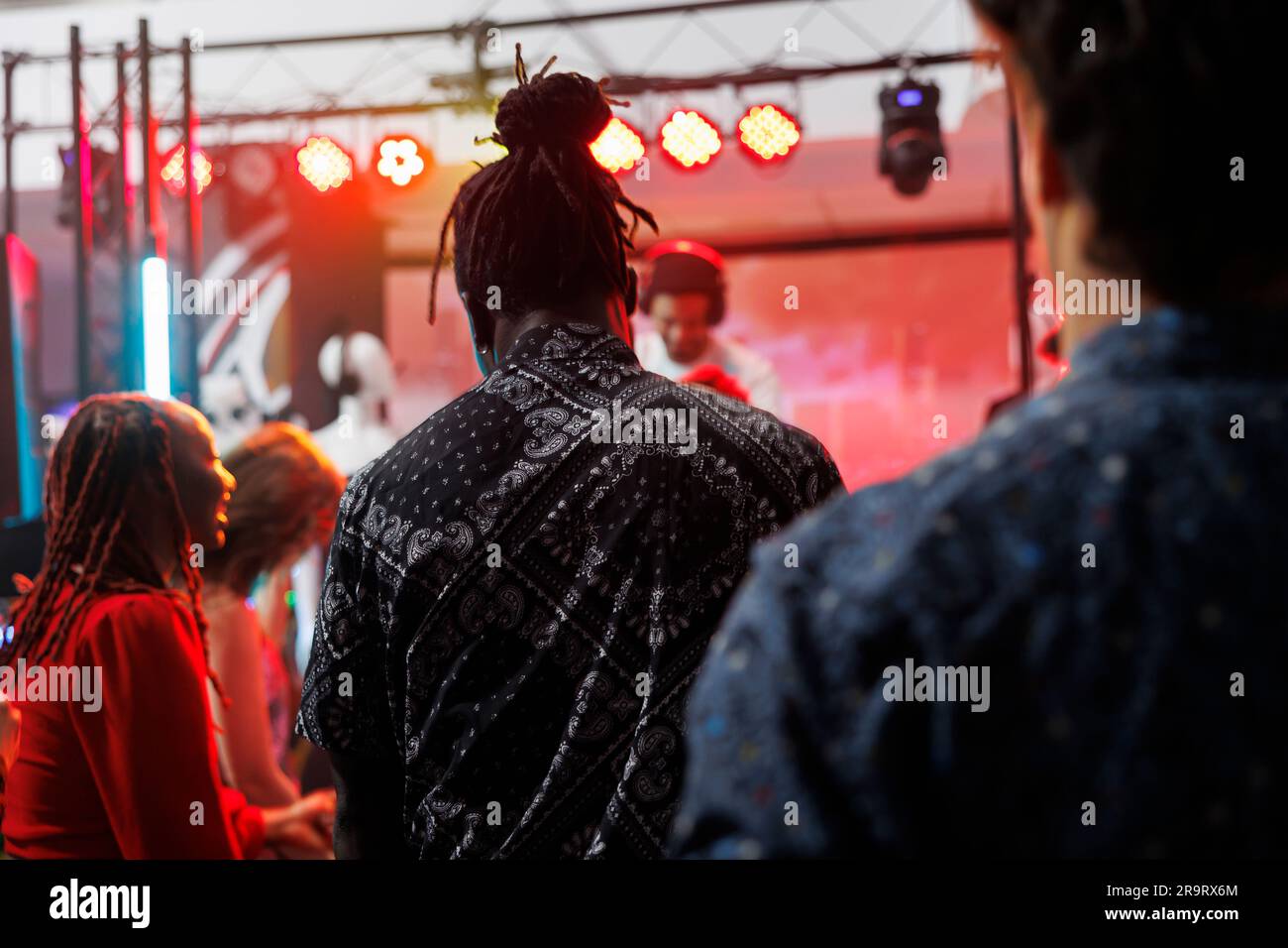 Diverse clubbers partying on dancefloor while attending electronic ...