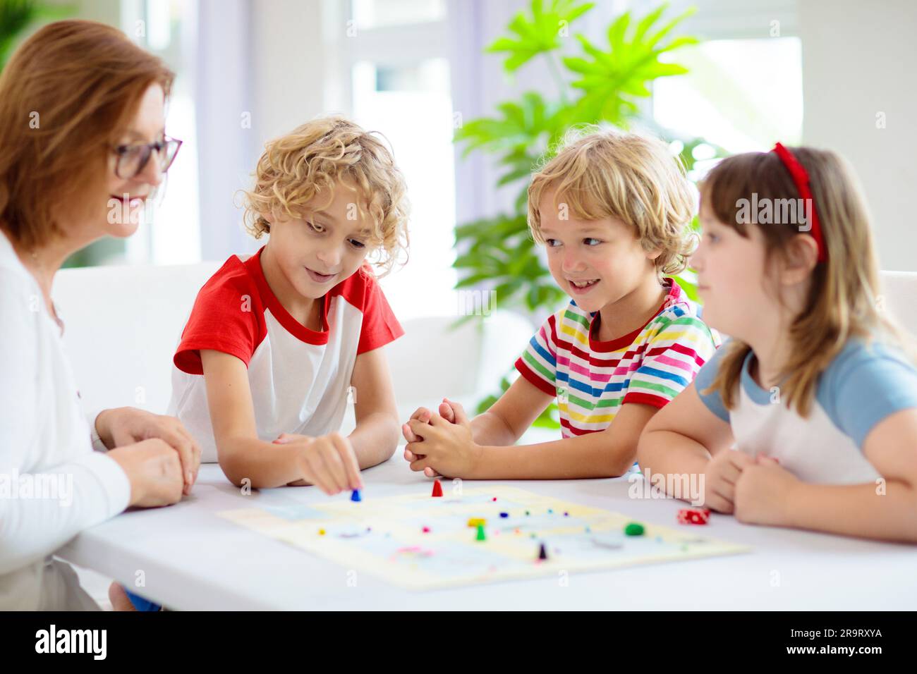 Family playing board game at home. Kids play strategic game. Little boy ...