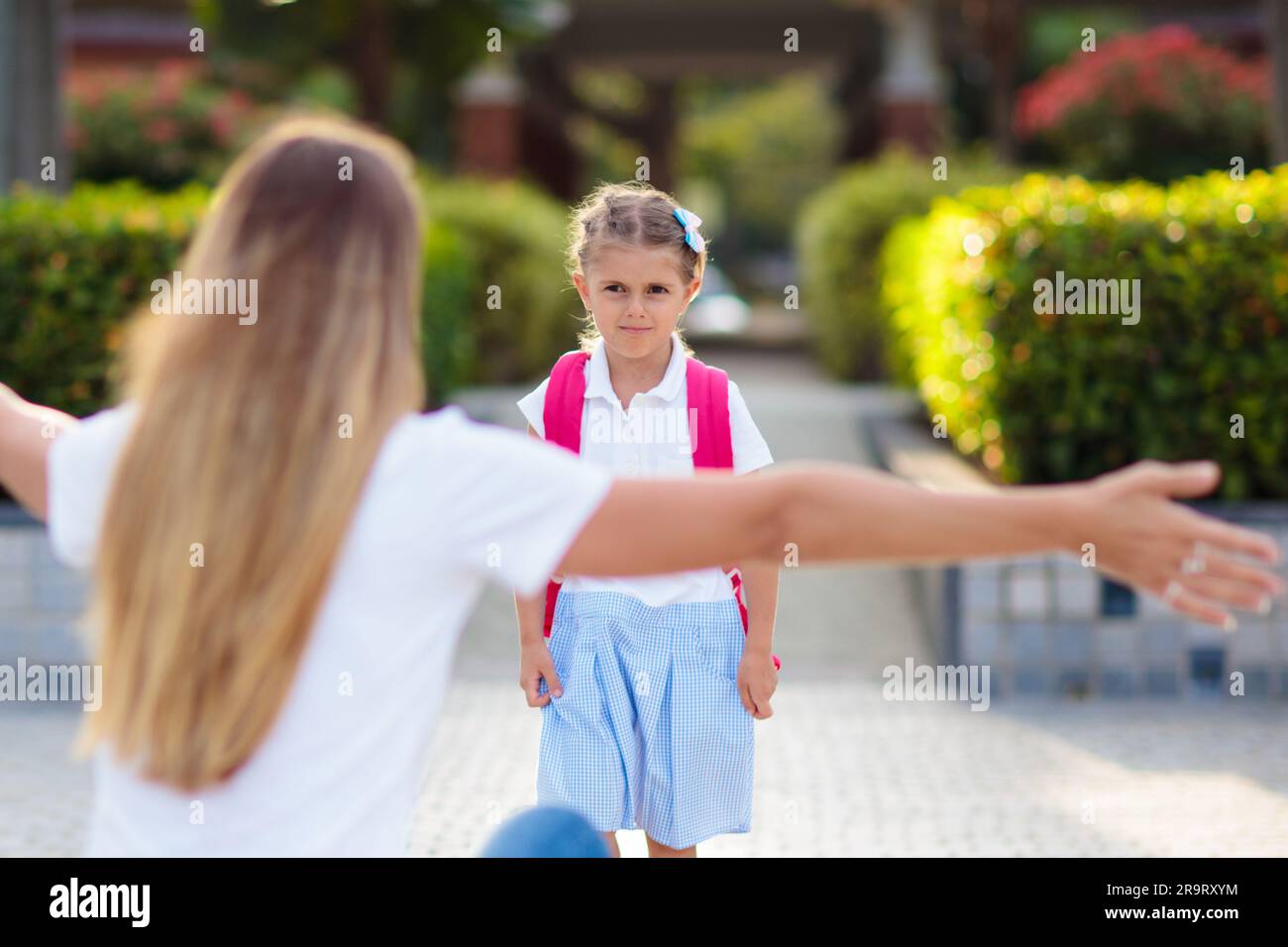 Mother and kids after school. Young mom picking up children after ...