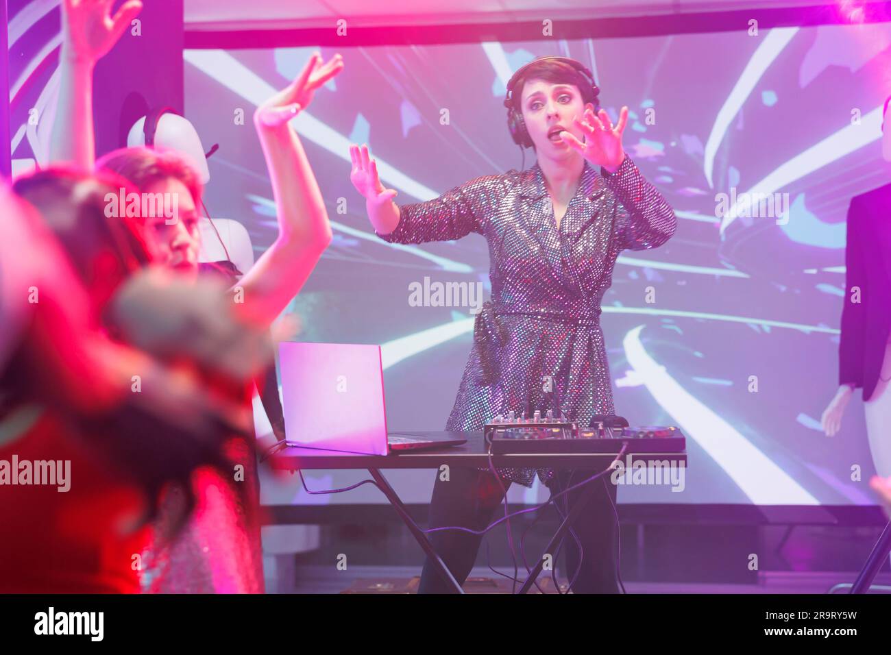 Woman mixing sound with dj station on stage and playing for crowd in ...