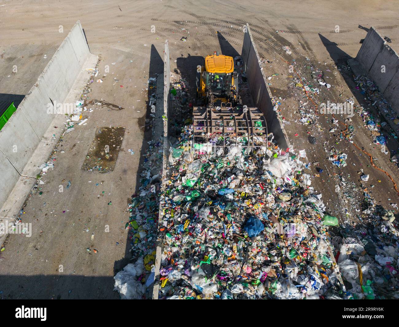 Skid steer loader moving plastic garbage with scrap grapple on the ...
