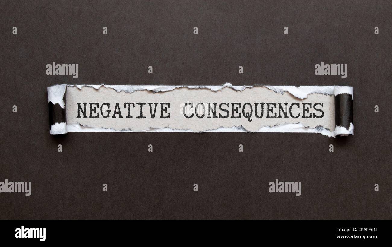 Closeup on businessman holding a card with text NEGATIVE CONSEQUENCES ...