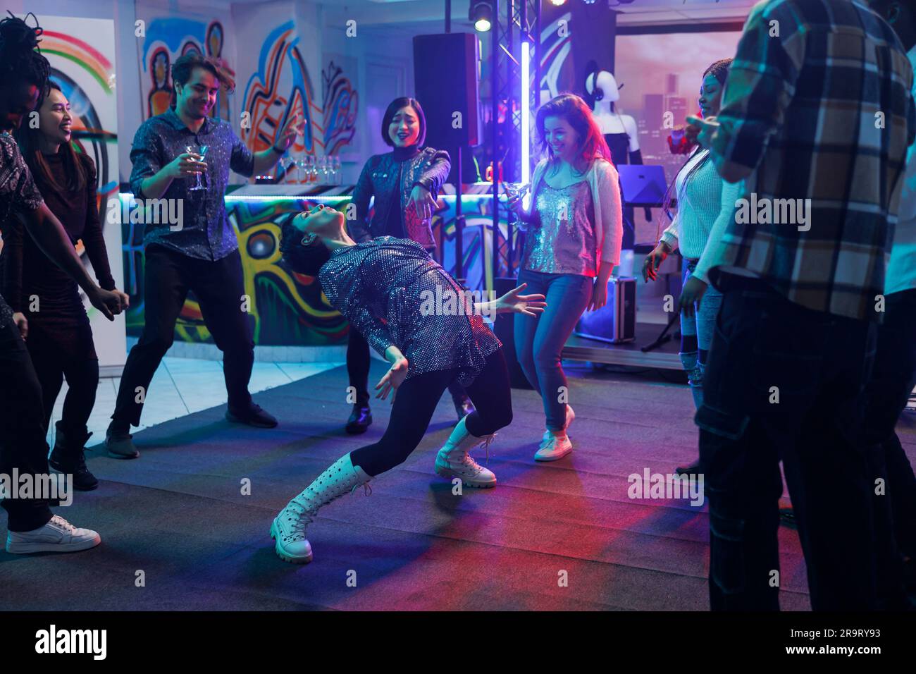 Friends watching woman dancing in nightclub, laughing while attending ...