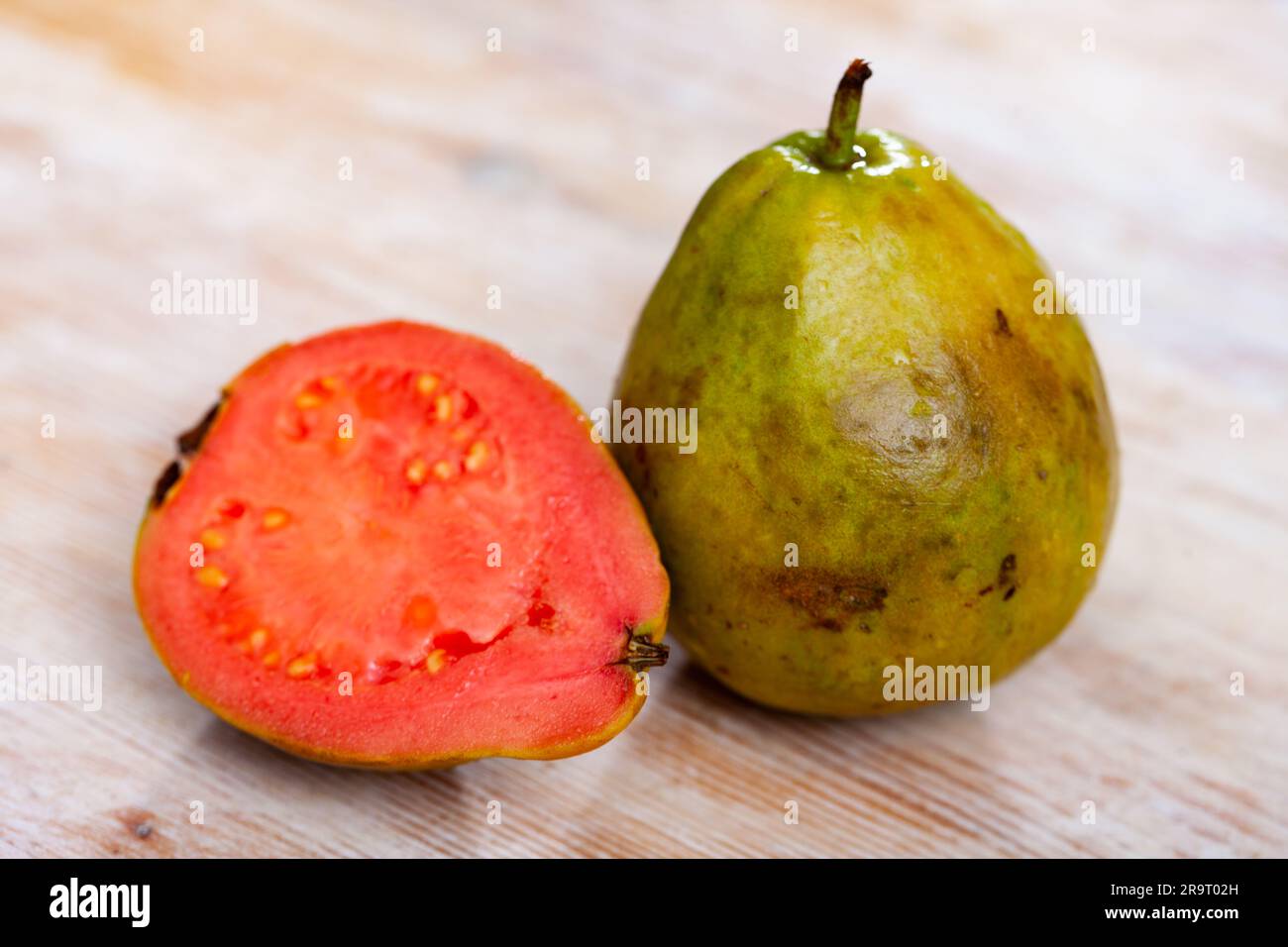 Fresh organic red guavas fruit cut in half on a wooden board. Exotic ...