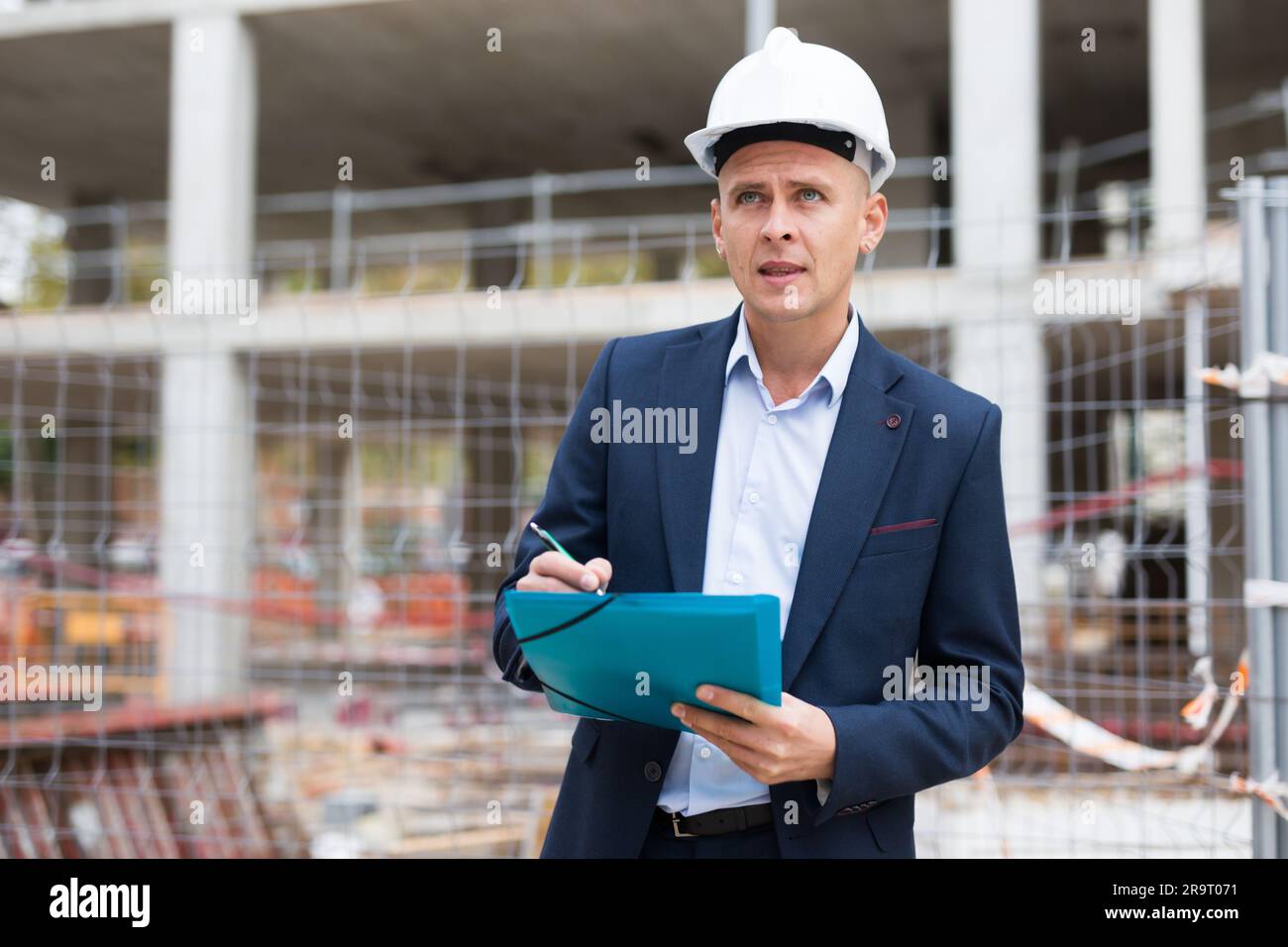 Male engineer checking work process in construction site Stock Photo ...