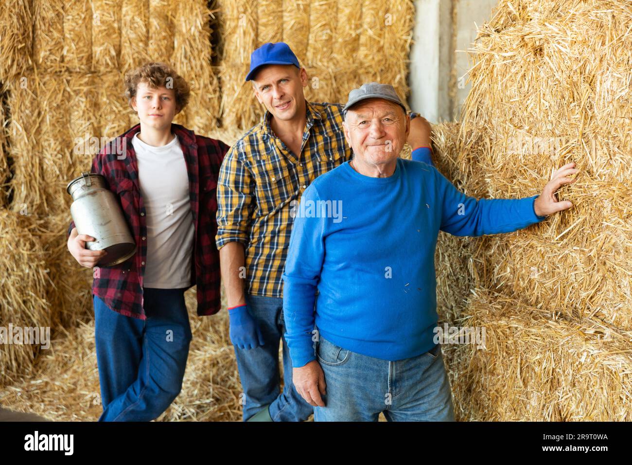 Three farm workers of different ages in barn Stock Photo - Alamy