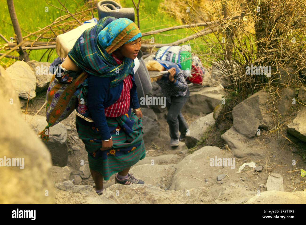 India, Himalayas - March 14, 2018: Sherpas on a mountain trail. Behind ...