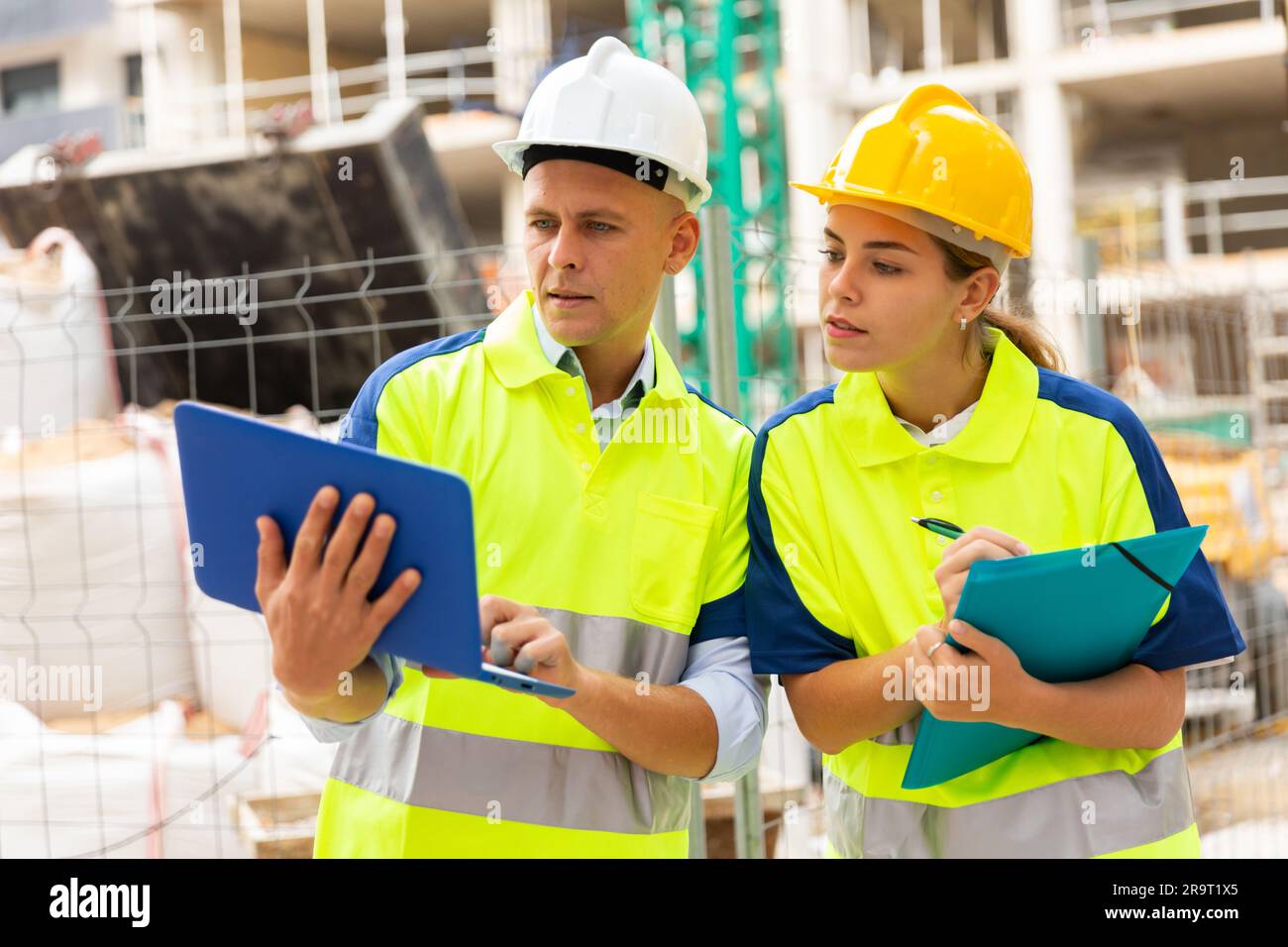 Male and female engineers in construction area Stock Photo - Alamy