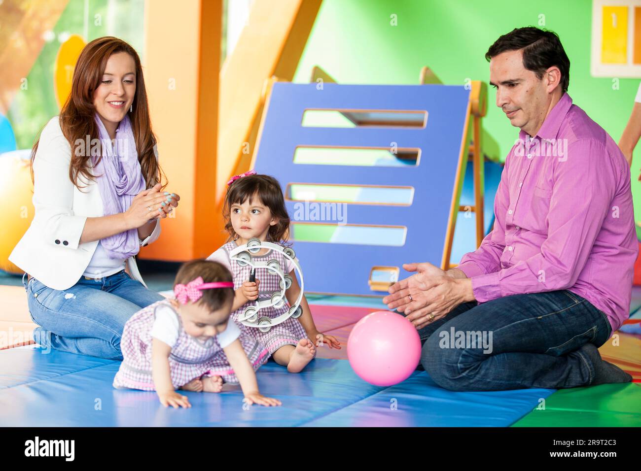 Young parents playing with their daughters. Early stimulation for ...