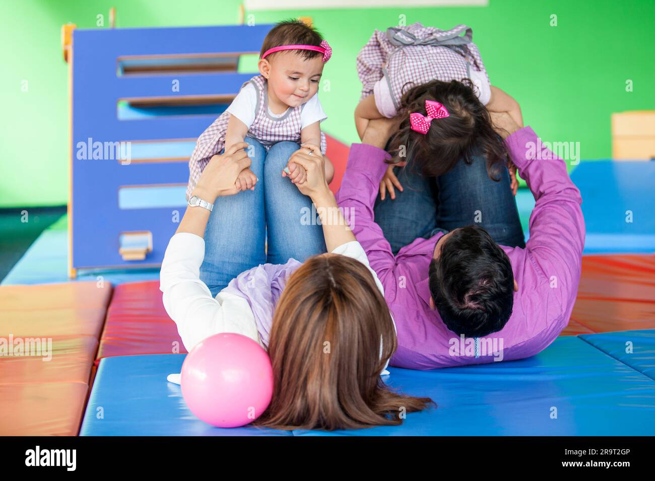 Young parents playing with their daughters. Early stimulation for ...
