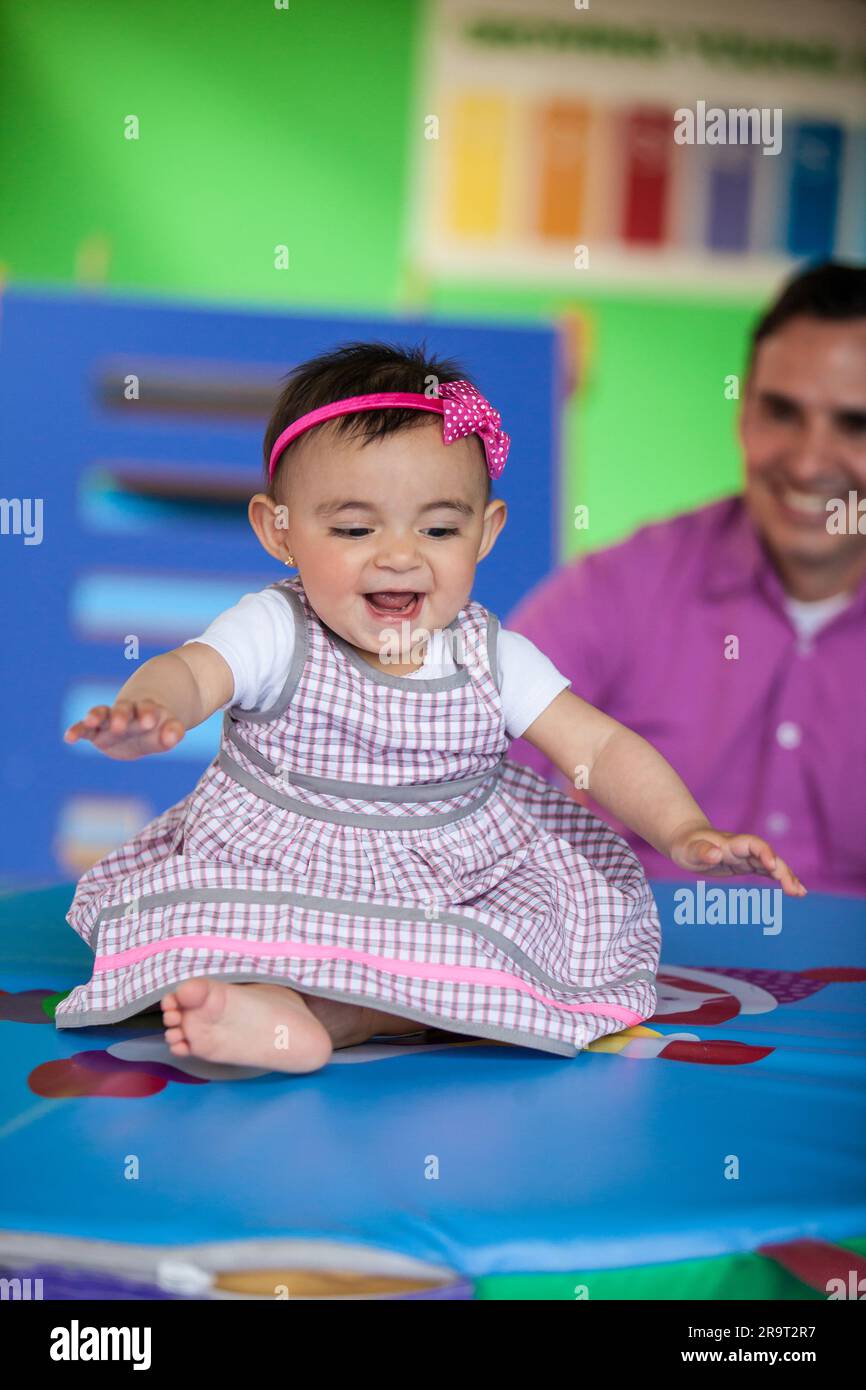 Beautiful ten months baby girl playing with her father on background ...