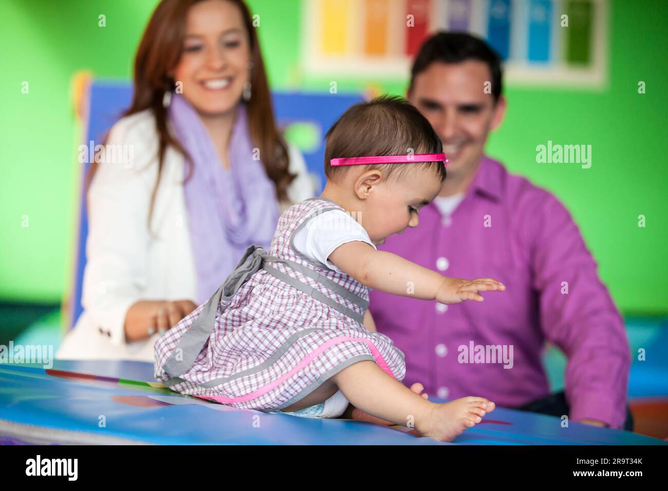 Beautiful ten months baby girl playing with her parents on background ...