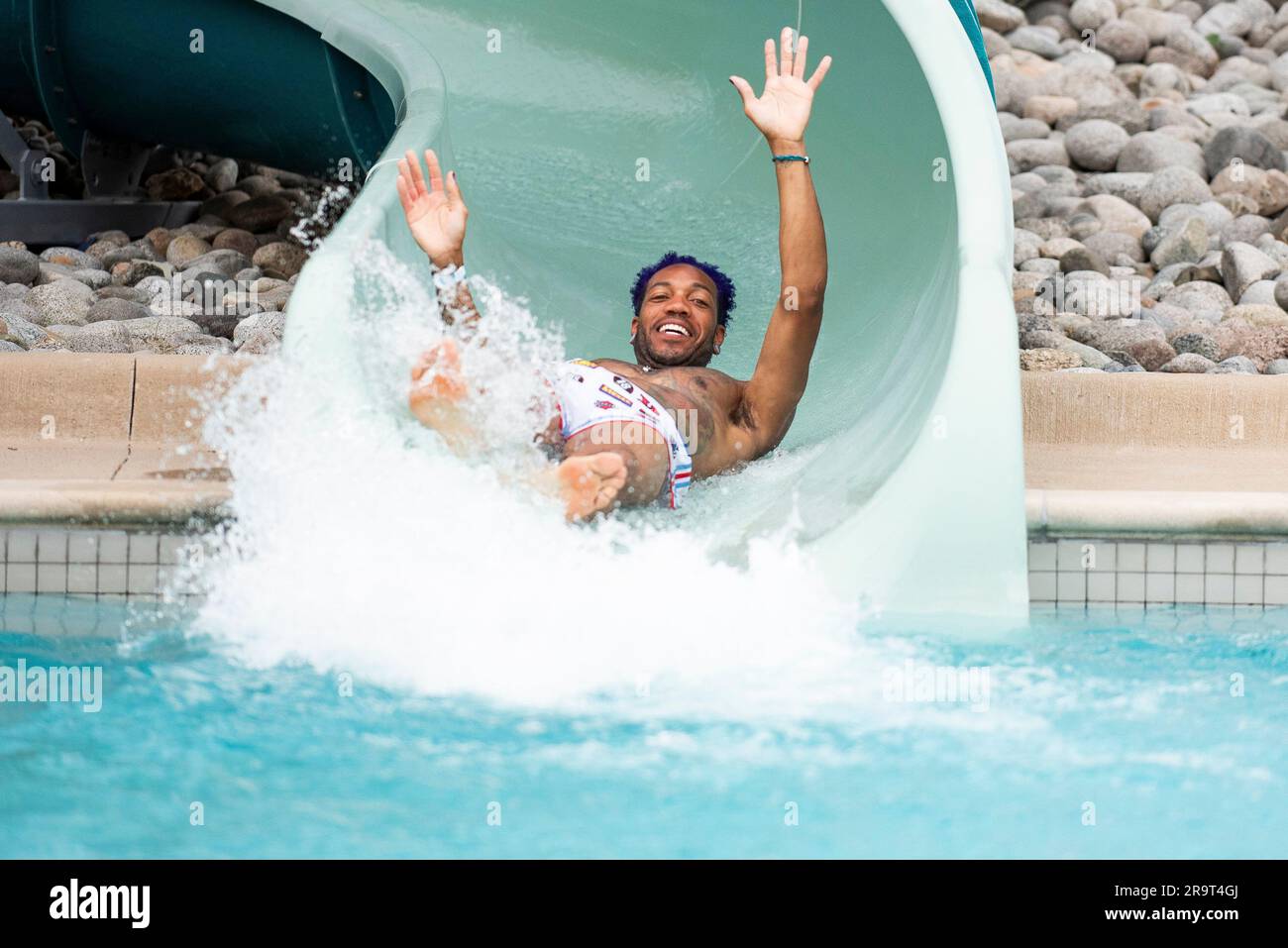 Derrick Anthony slides down a water slide during the Dallas Southern Pride Juneteenth Unity ...