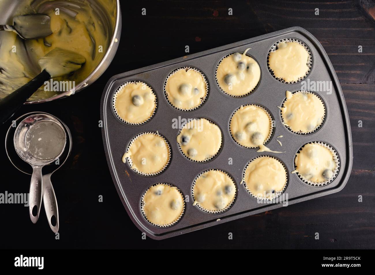 Muffin Tin Lined with Paper Wrappers and Filled with Blueberry Muffin ...