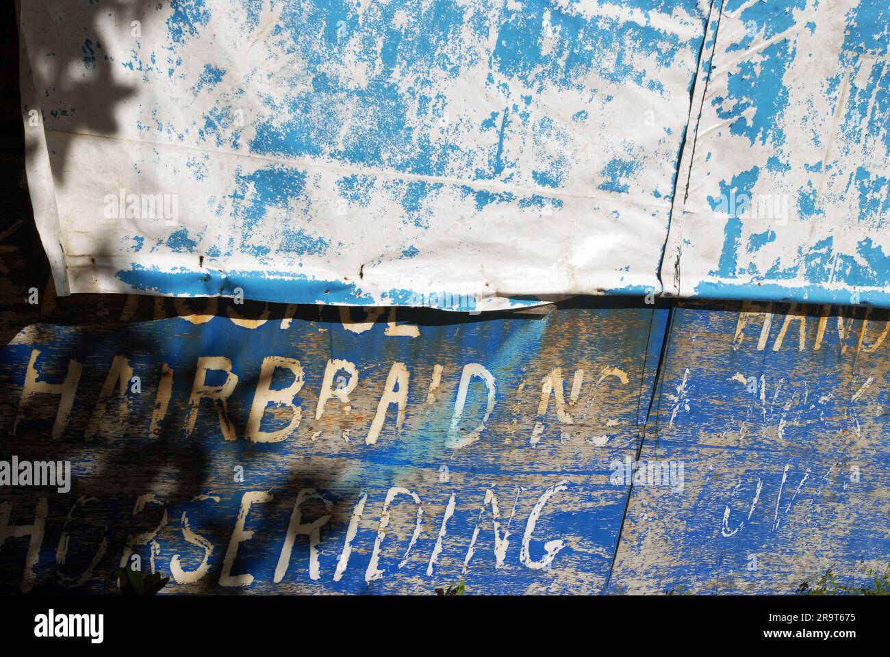 Hand written advertising painted on side of blue hut, Hair braiding and ...
