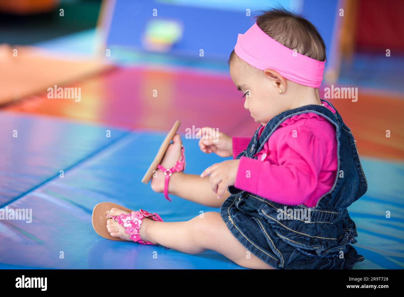Portrait of a beautiful ten months baby girl on a colorful background ...