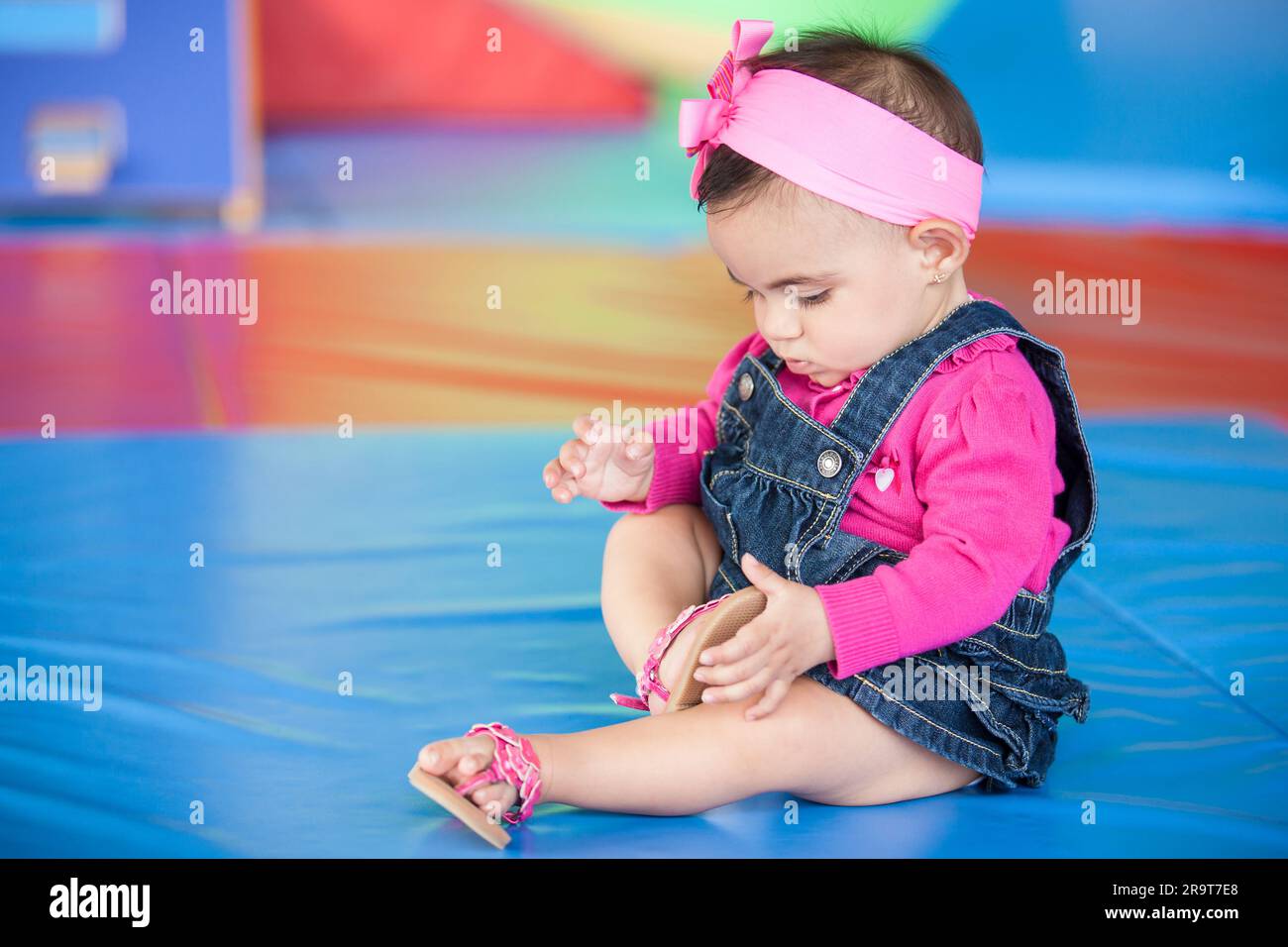 Portrait of a beautiful ten months baby girl on a colorful background ...