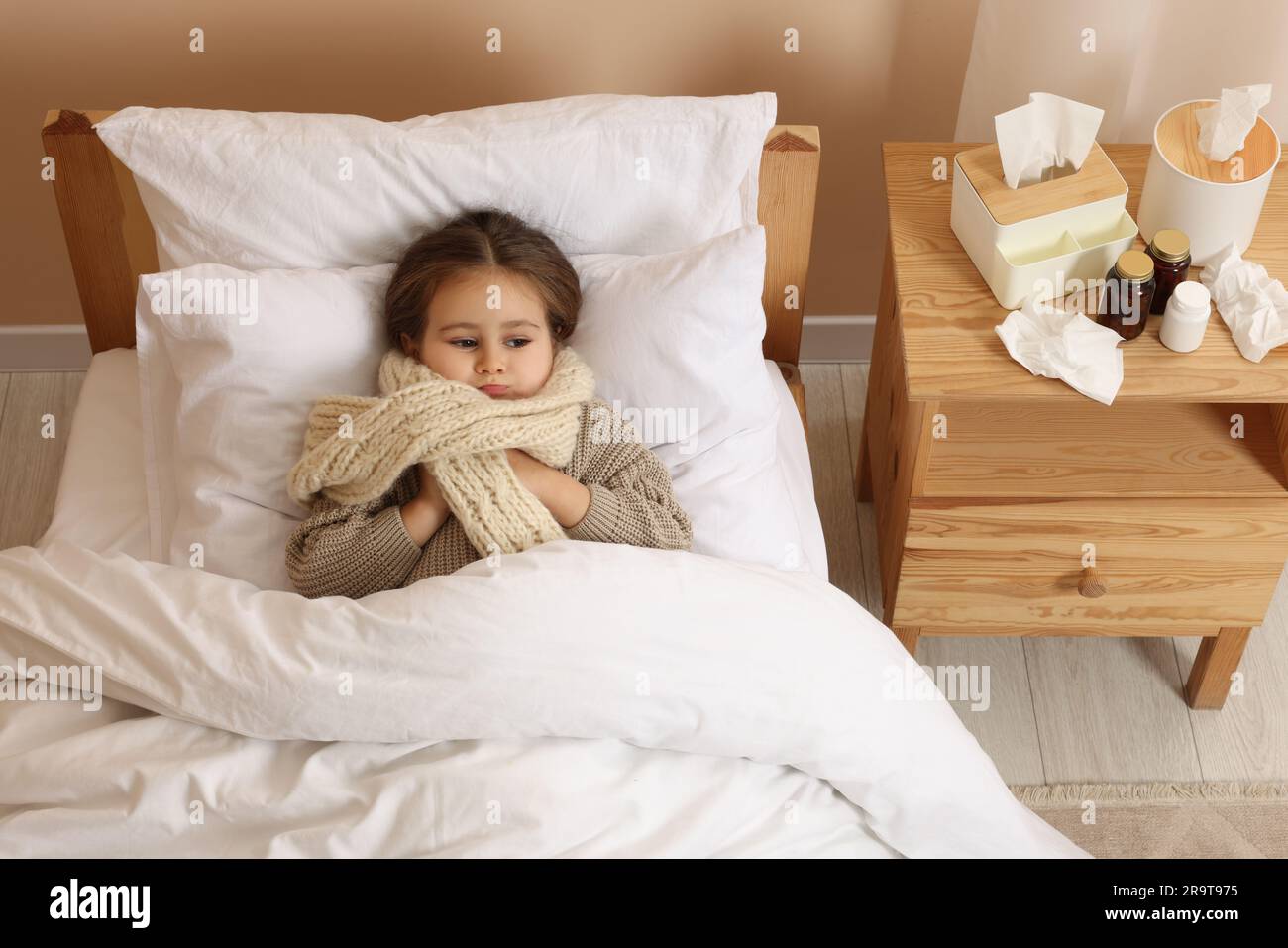 Sick girl with scarf around neck lying in bed at home, above view Stock ...