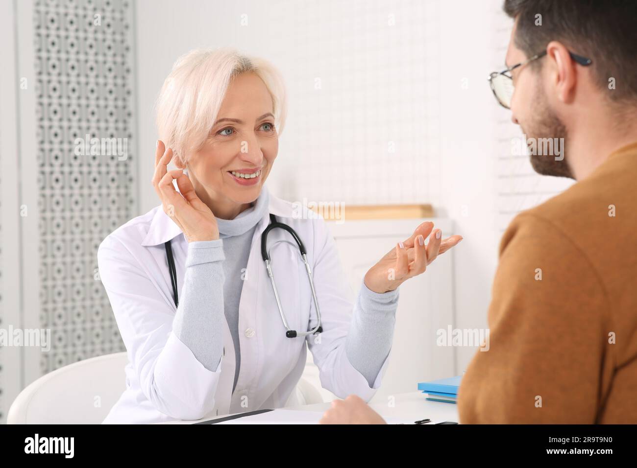 Professional female doctor consulting patient in clinic Stock Photo - Alamy