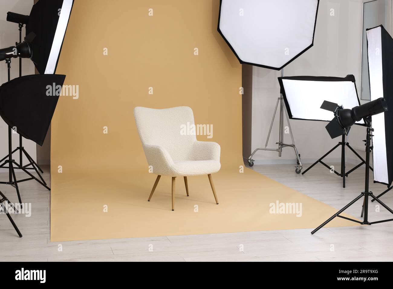 Interior of modern photo studio with armchair and professional lighting ...