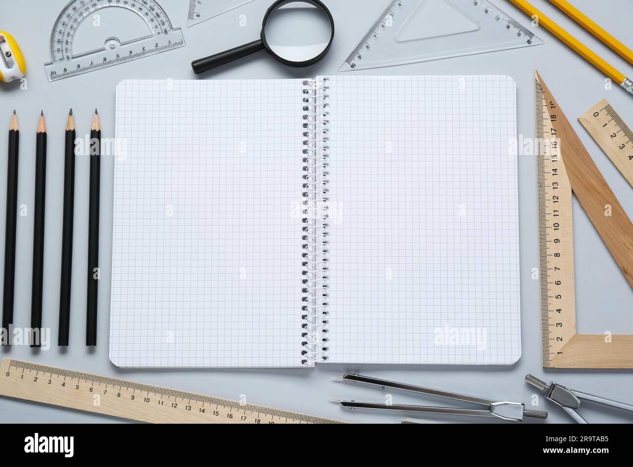 Different rulers, notebook and other stationery for drawing on light ...