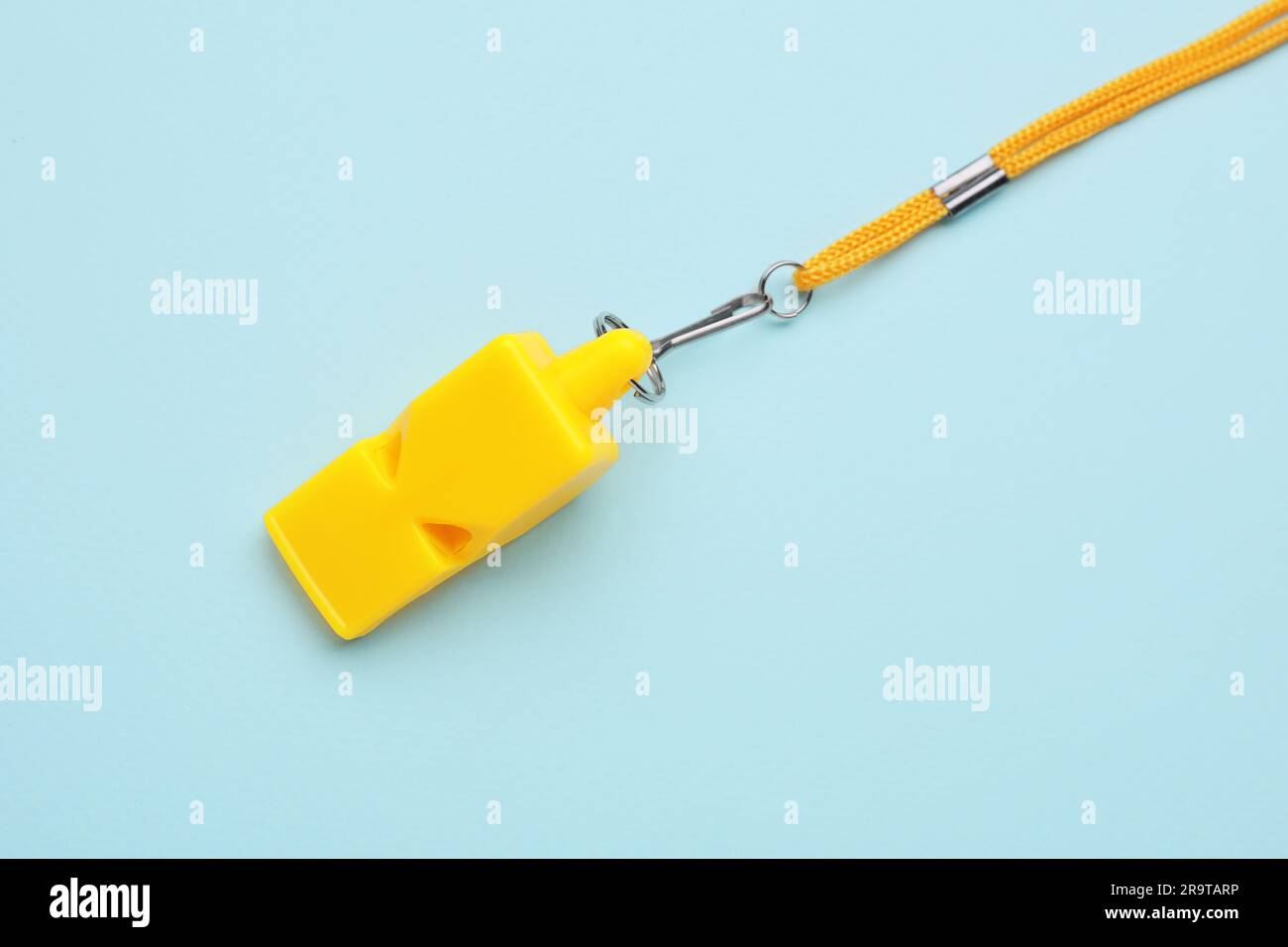 One yellow whistle with cord on light blue background, top view Stock ...