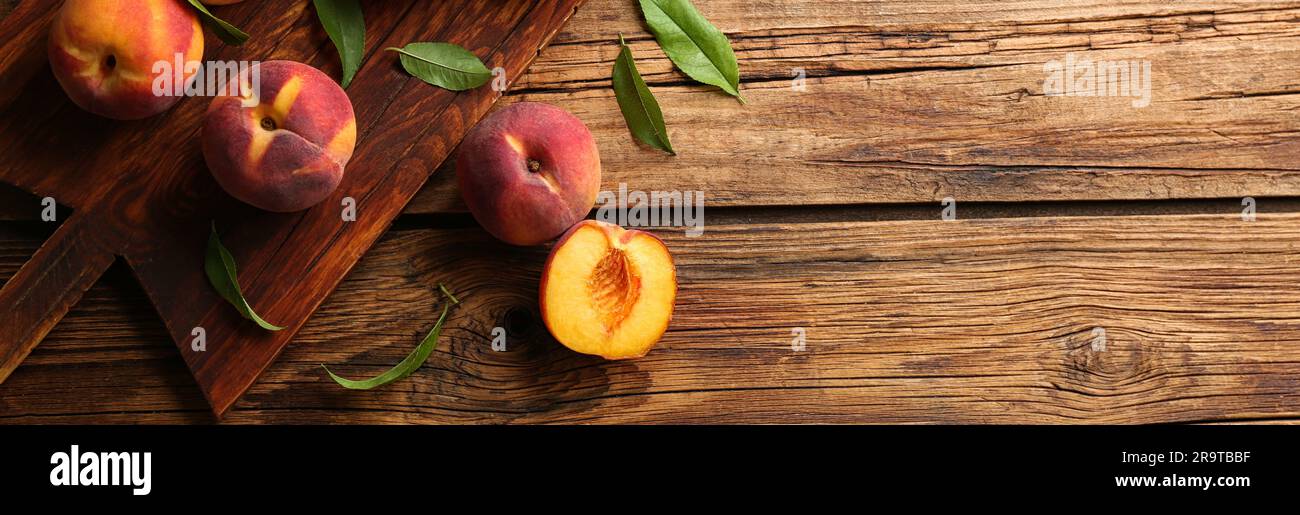 Fresh ripe peaches on wooden table, top view. Banner design with space ...