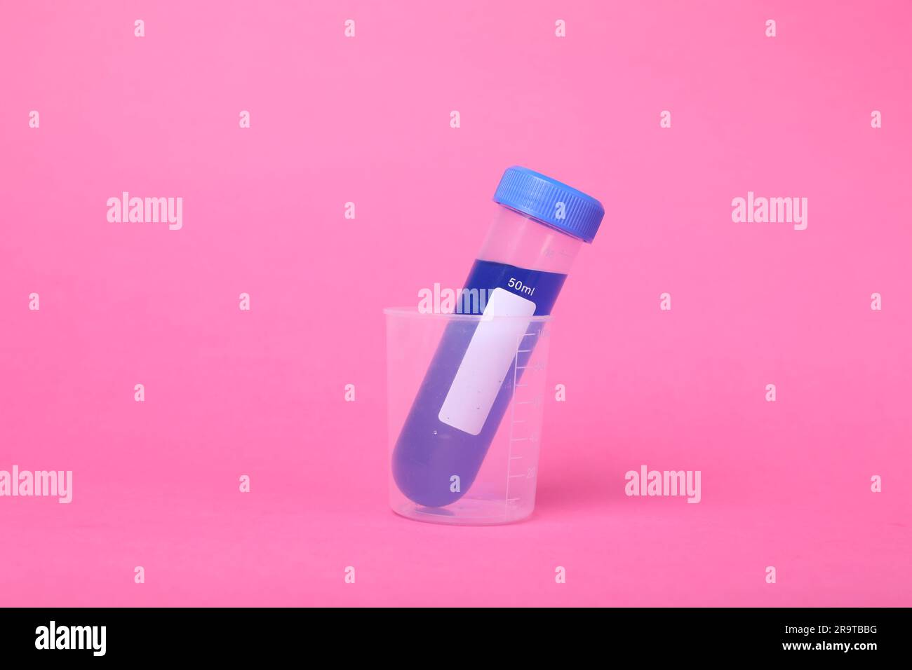 Beaker with test tube and liquid on bright pink background. Kids ...