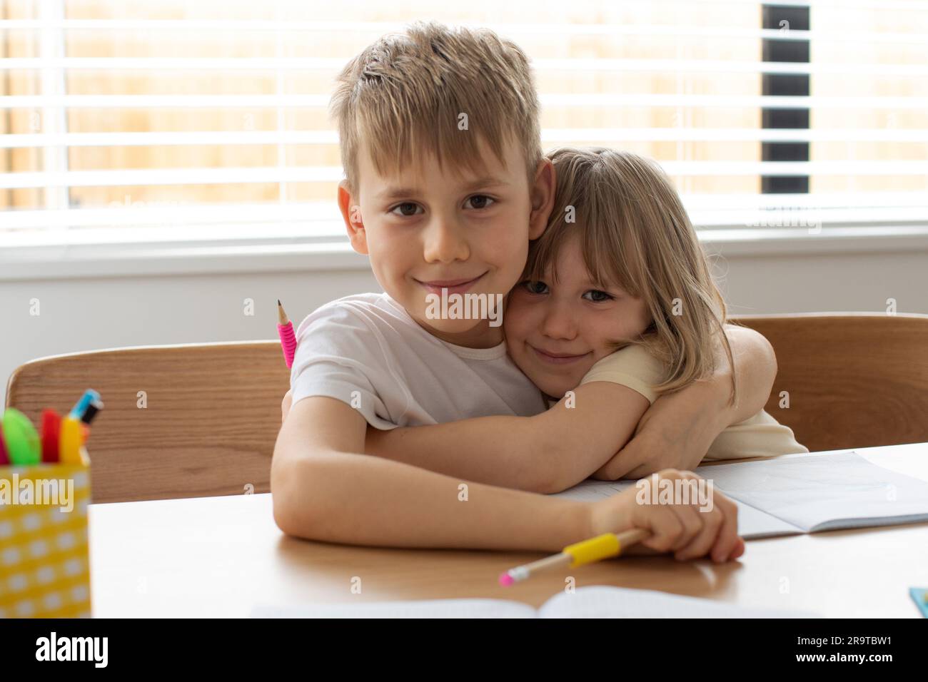 Brother and sister joyfully embrace after they have painted at the ...