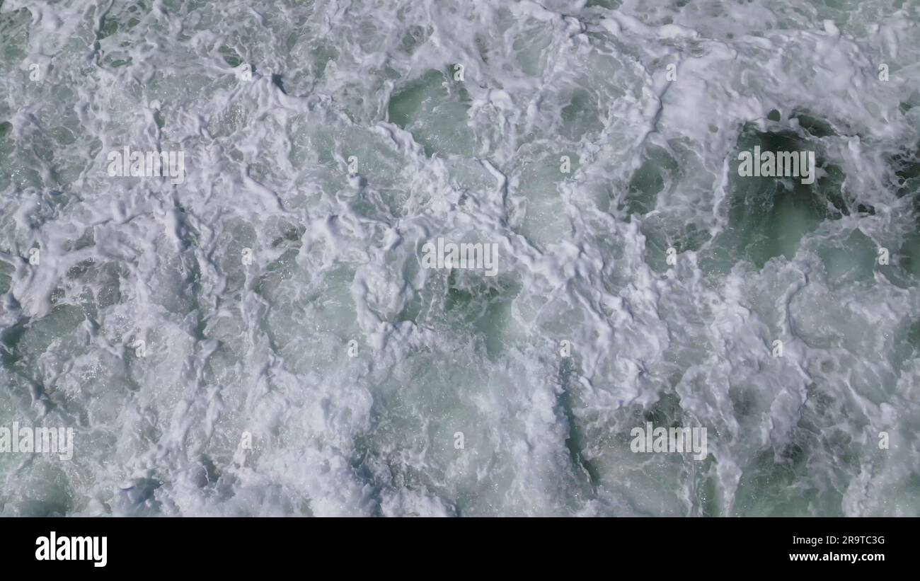 Overhead view of waves crashing on sandy beach aerial - a bird's eye ...