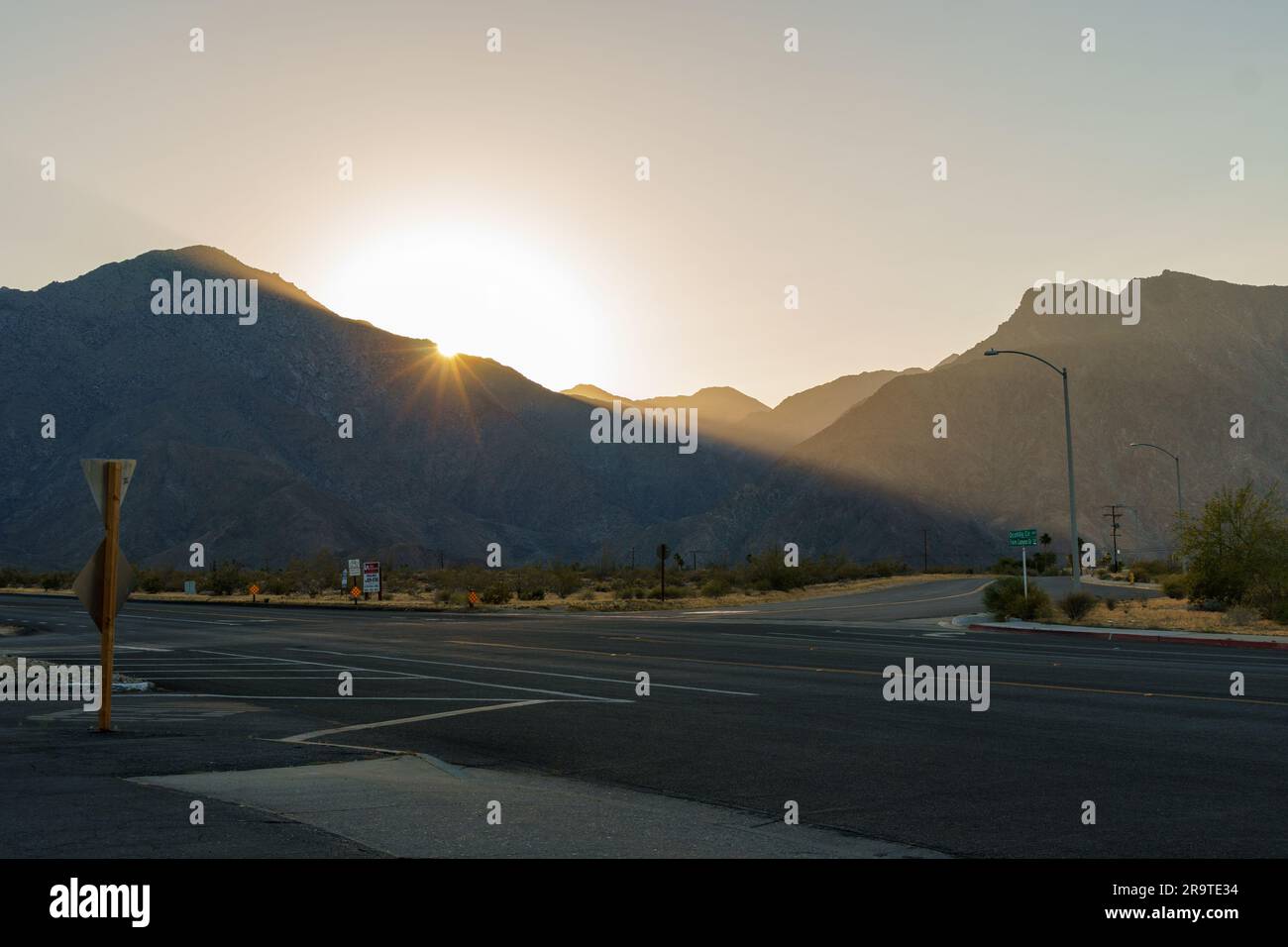 Sun setting over a hill with a beam of light stretching across an ...