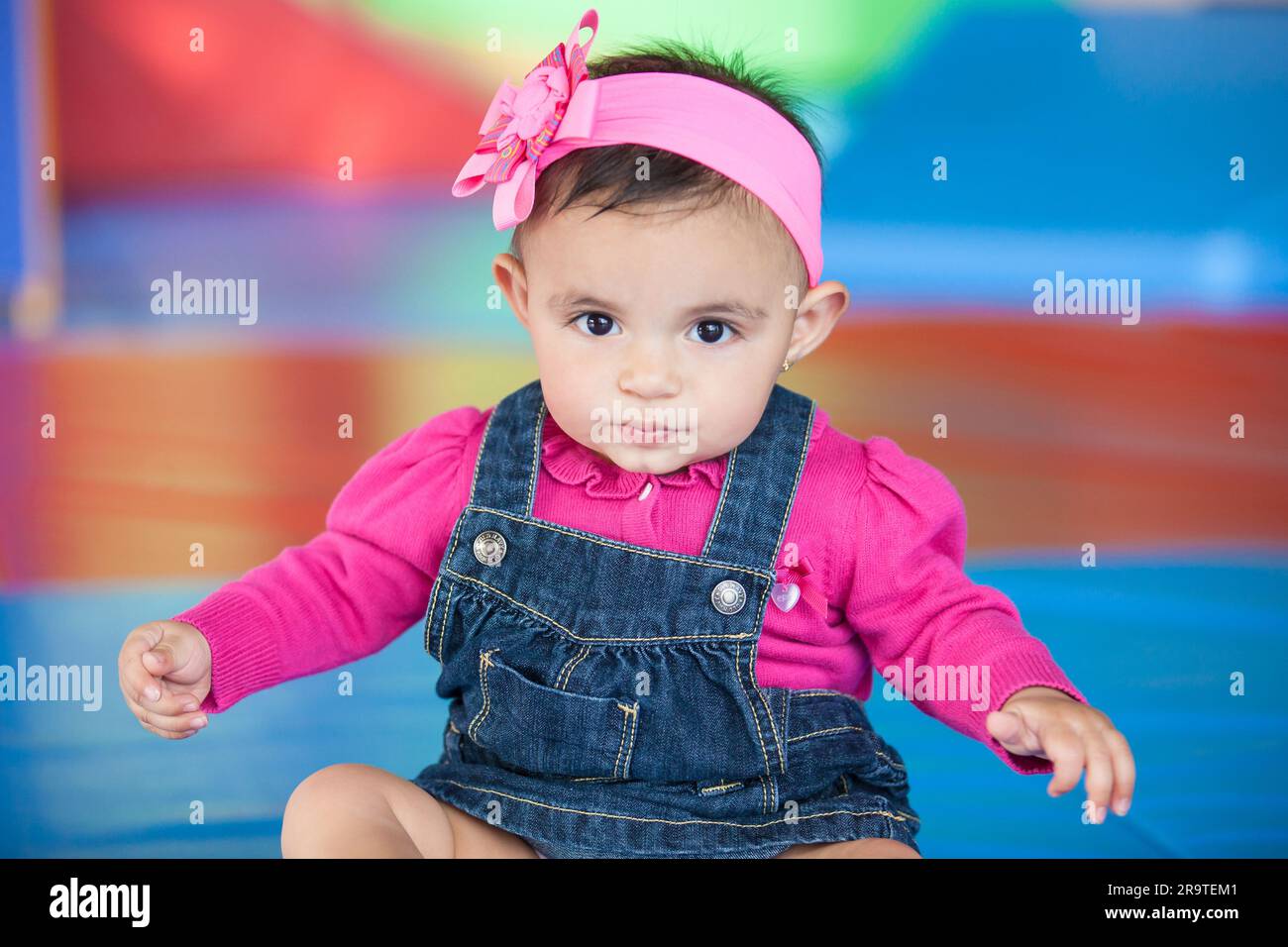 Portrait of a beautiful ten months baby girl on a colorful background ...