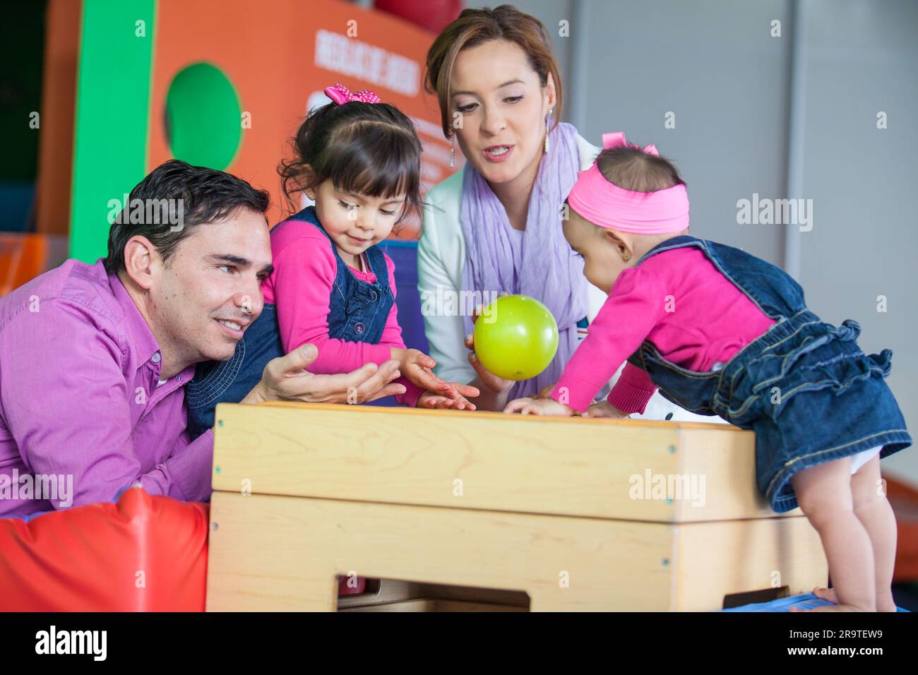 Young parents playing with their daughters. Early stimulation for ...