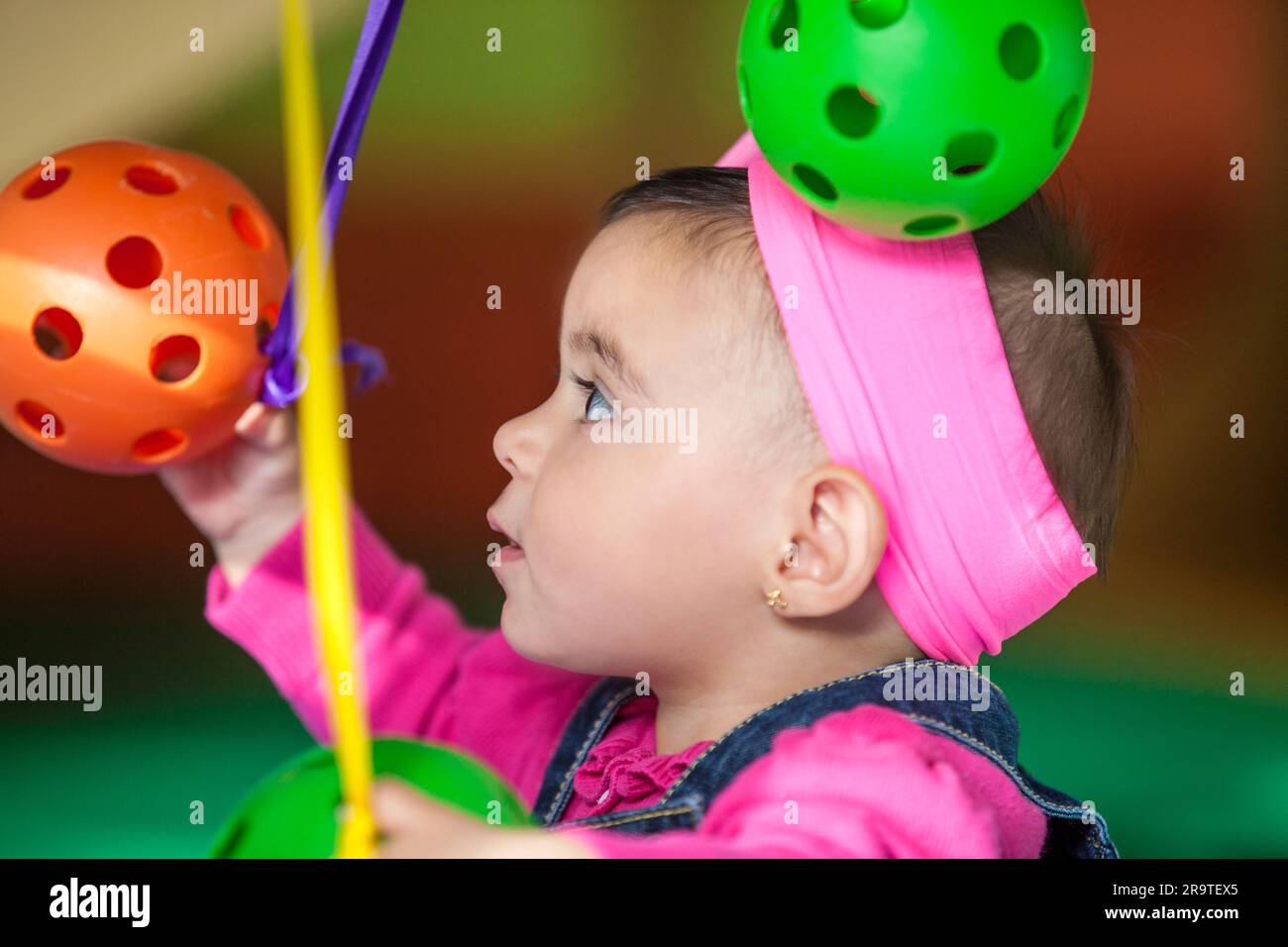 Beautiful ten months baby girl playing with colorful balls. Early ...