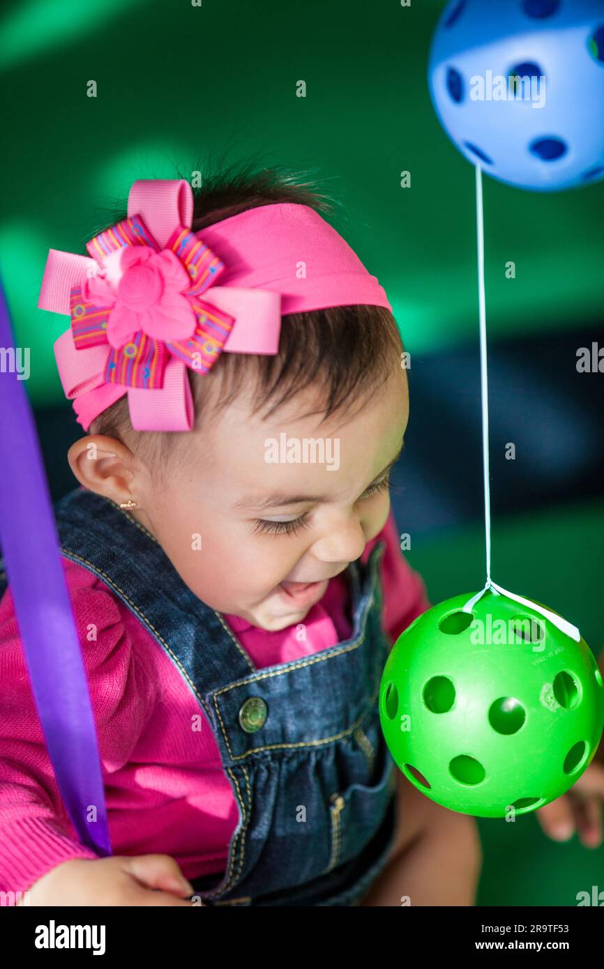 Beautiful ten months baby girl playing with colorful balls. Early ...