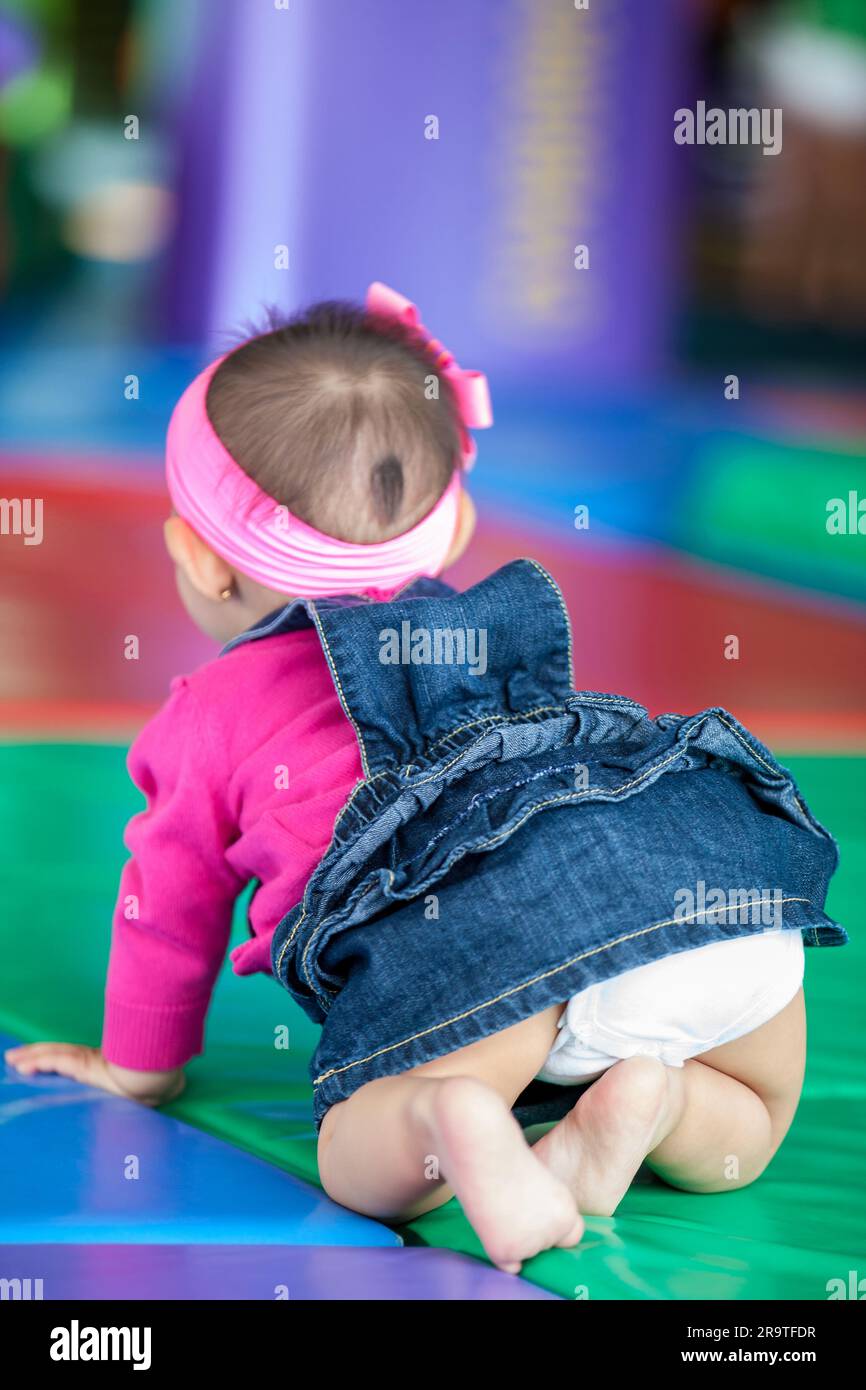Beautiful ten months baby girl crawling on a colorful background. Early ...