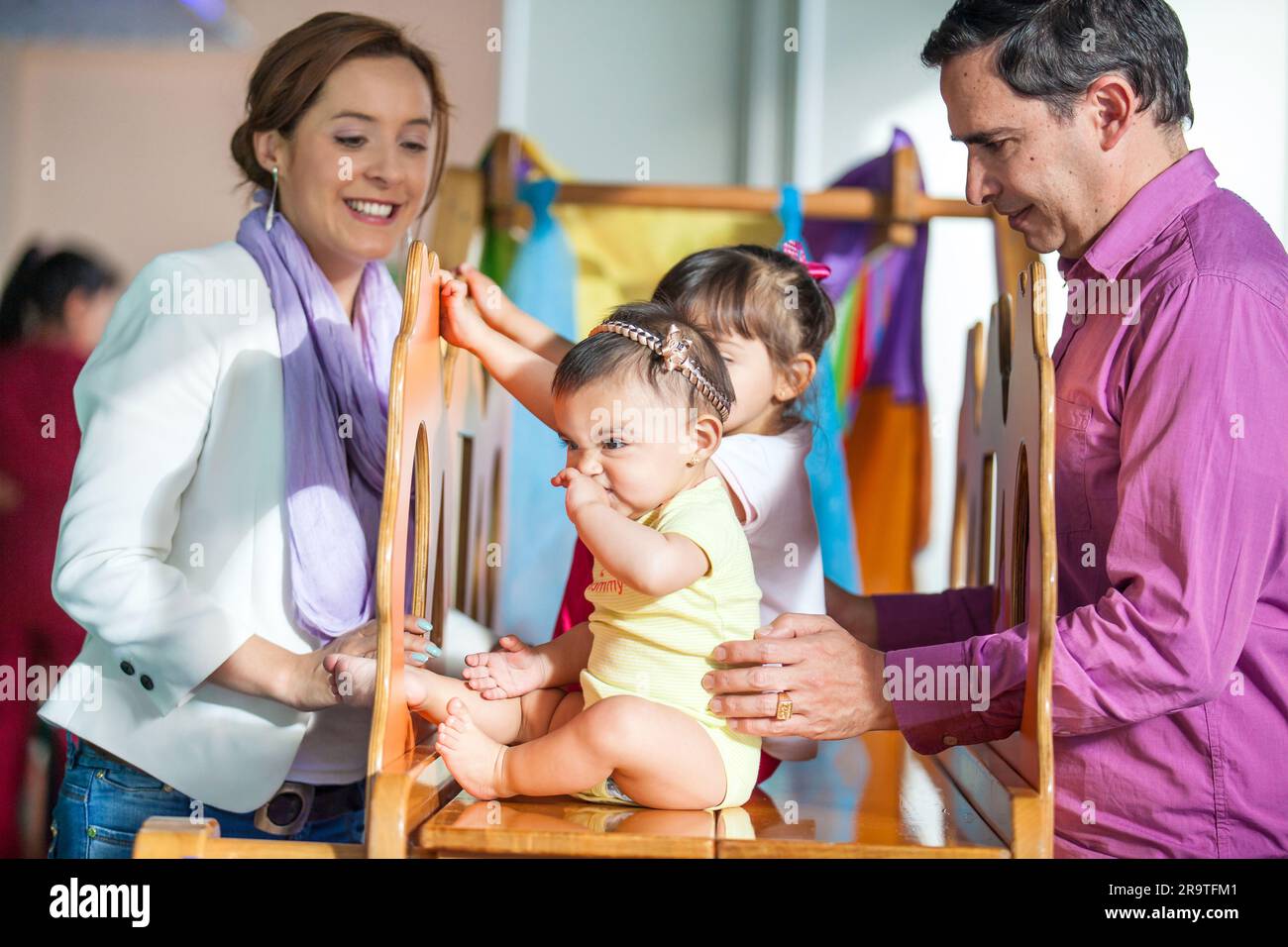 Beautiful ten months baby girl playing with her family. Early ...