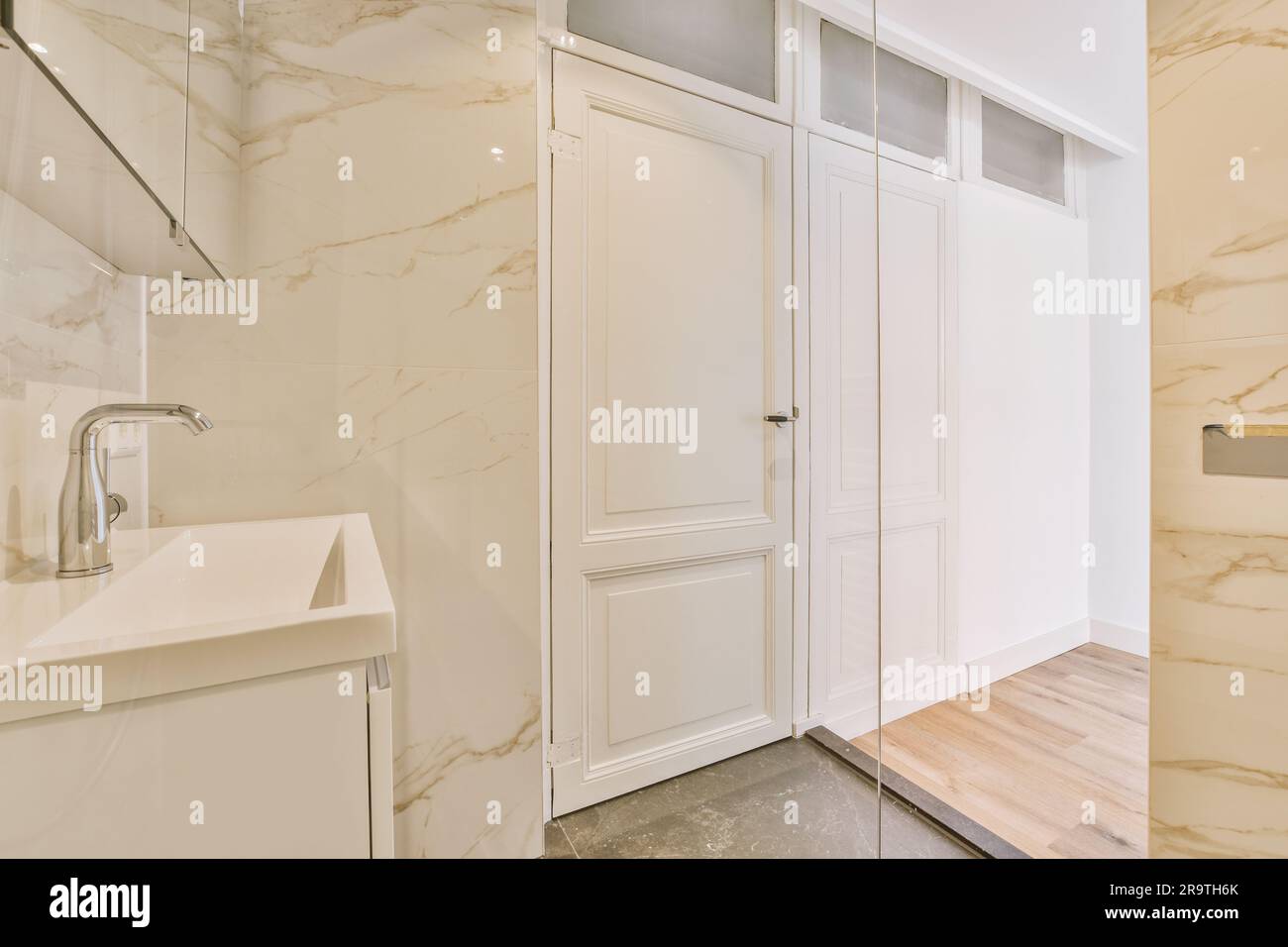 a modern bathroom with marble walls and flooring, including a white ...