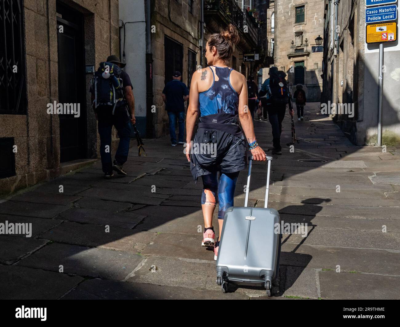 A pilgrim is seen walking with a suitcase. The Camino de Santiago (the ...