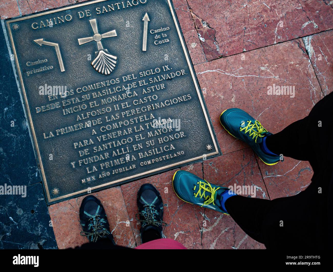 Two pilgrims are seen placing their trail shoes around the stone that ...