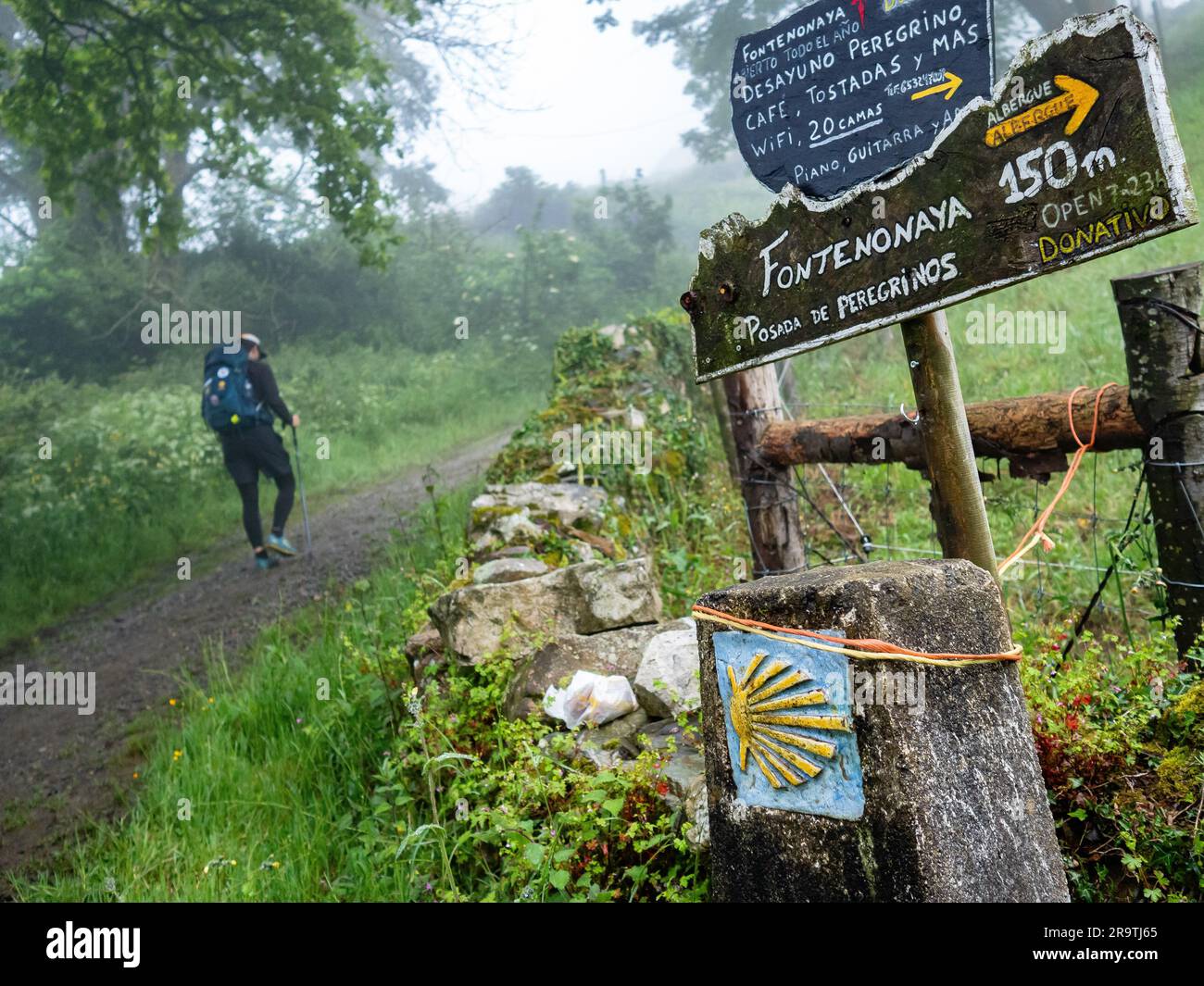A pilgrim is seen passing by several marks that are pointing places to ...