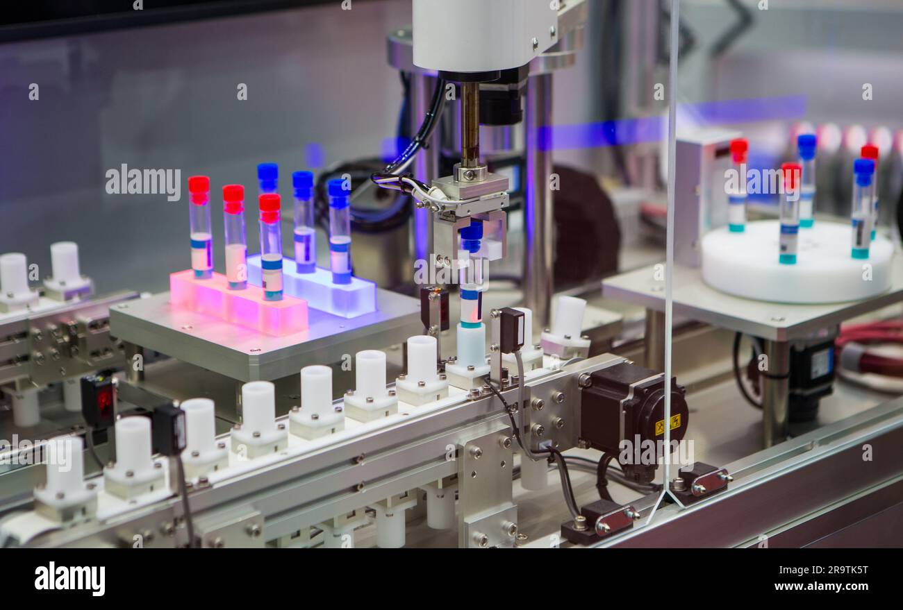 Automated process in laboratory. Robot arm with test tube virus in ...