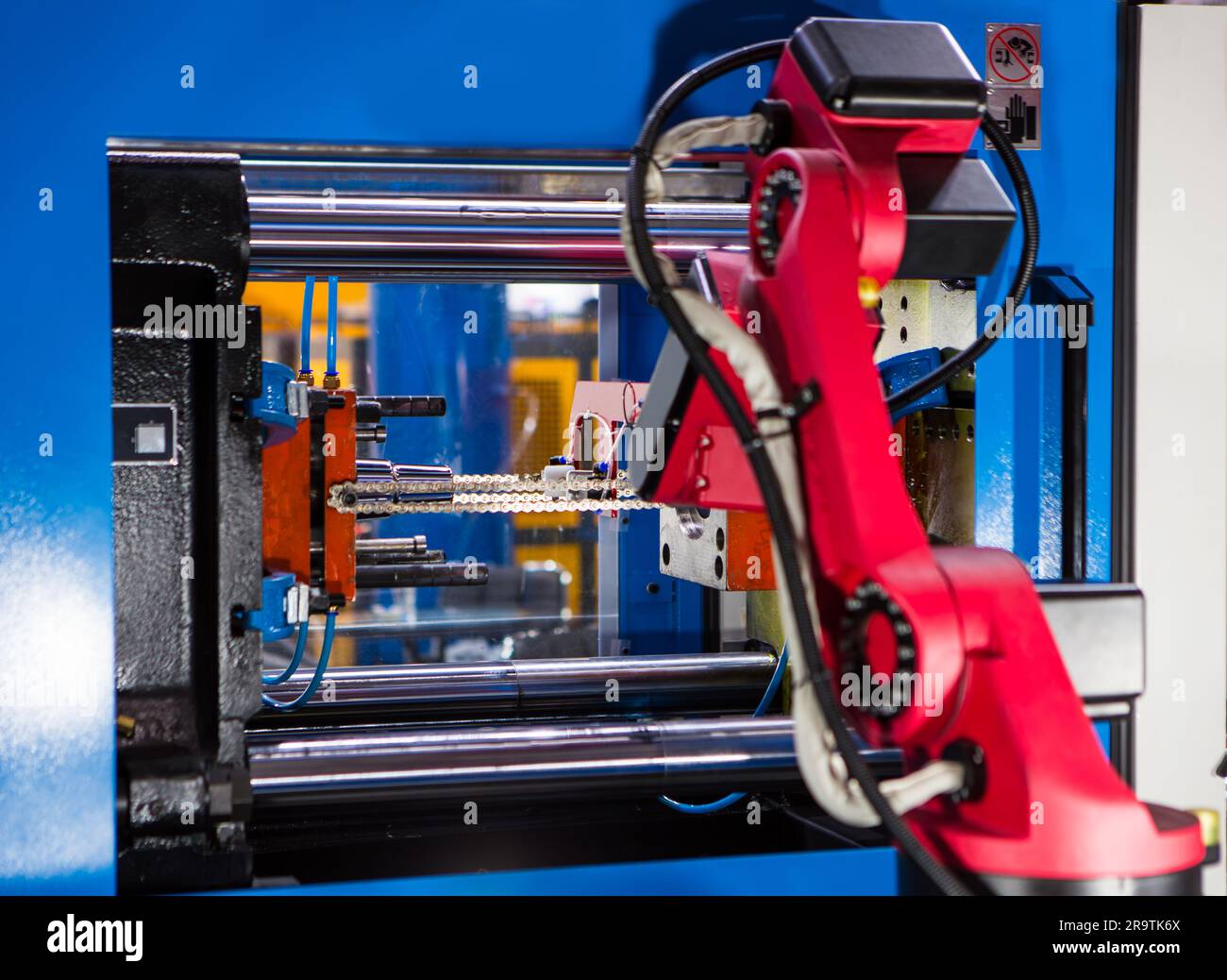 Automated manufacturing process. Robot arm remove finish products on injection molding machine ...