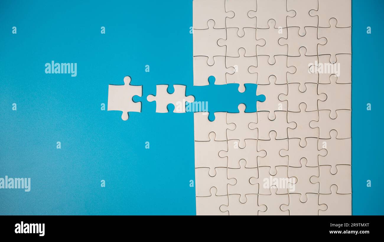 White part of jigsaw puzzle pieces on blue background. concepts of ...