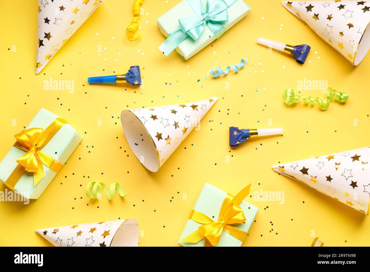 Different party decor on yellow background Stock Photo - Alamy