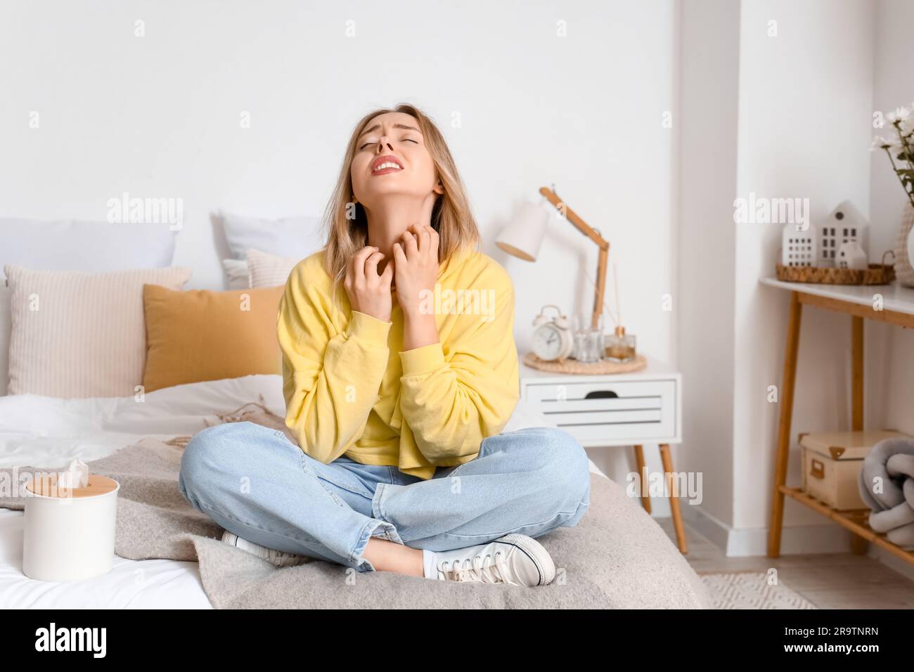 Allergic young woman scratching in bedroom Stock Photo - Alamy