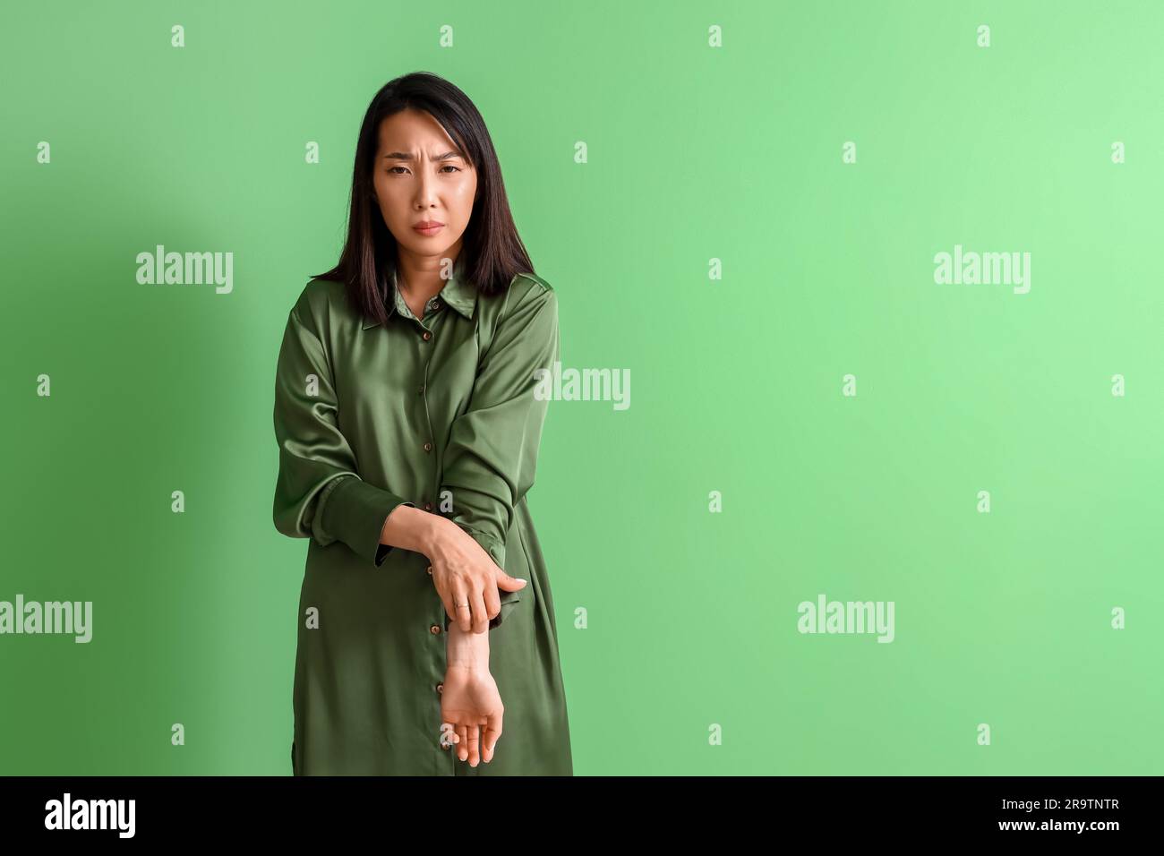 Allergic Asian woman scratching on green background Stock Photo - Alamy