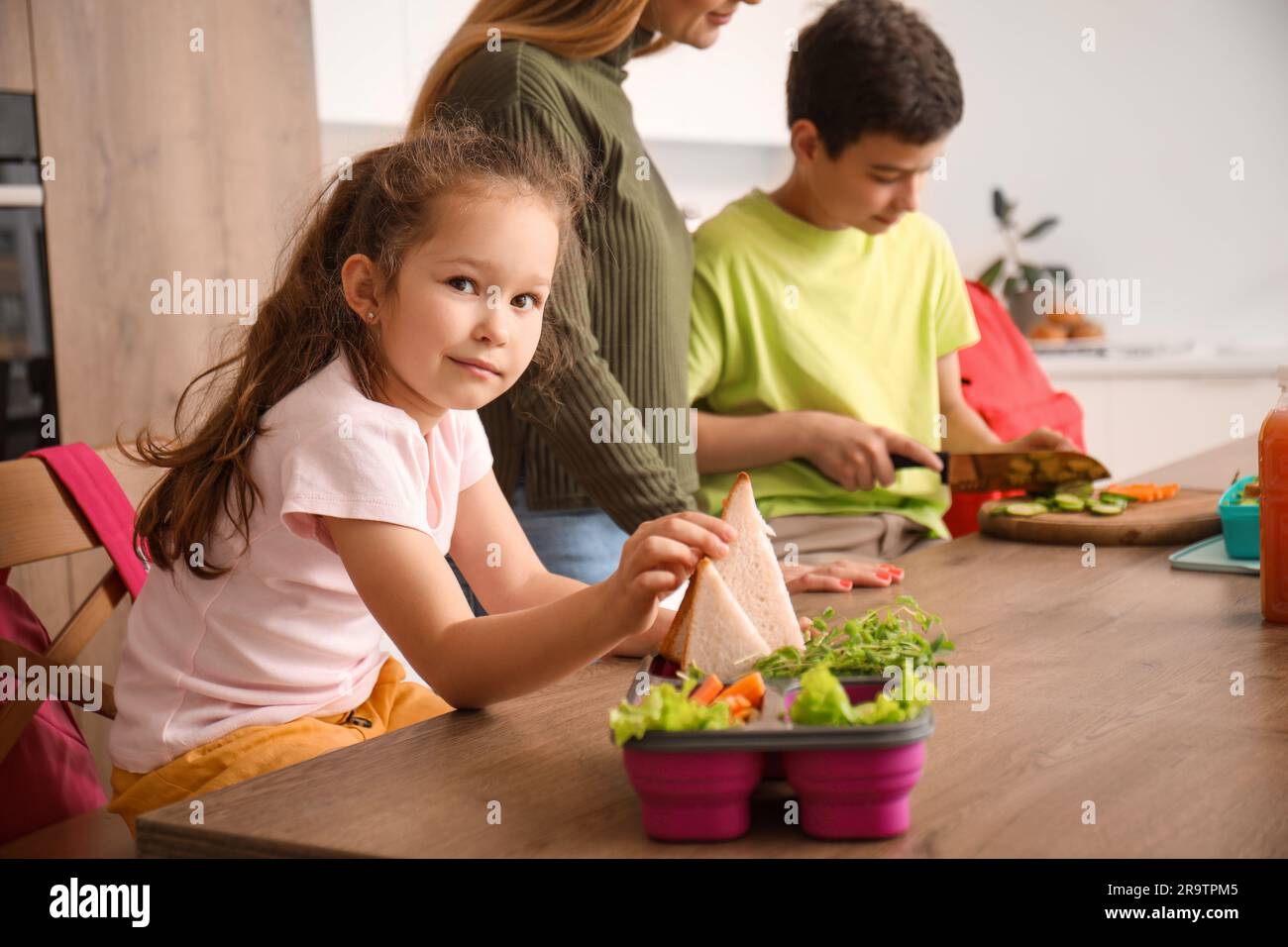 Little girl with school lunch in kitchen Stock Photo - Alamy